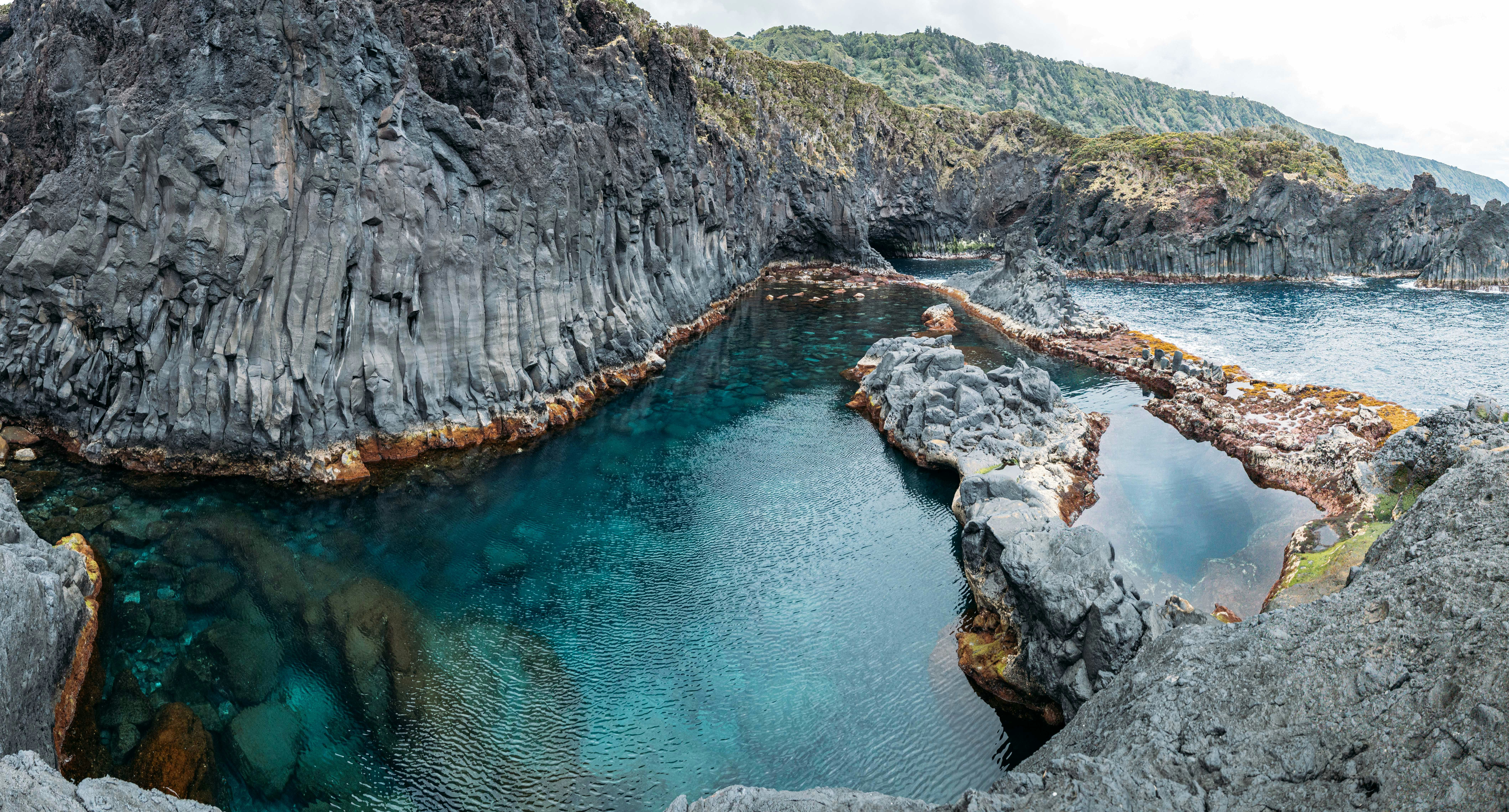 Hidden Azure Oasis Between Weathered Black Cliffs