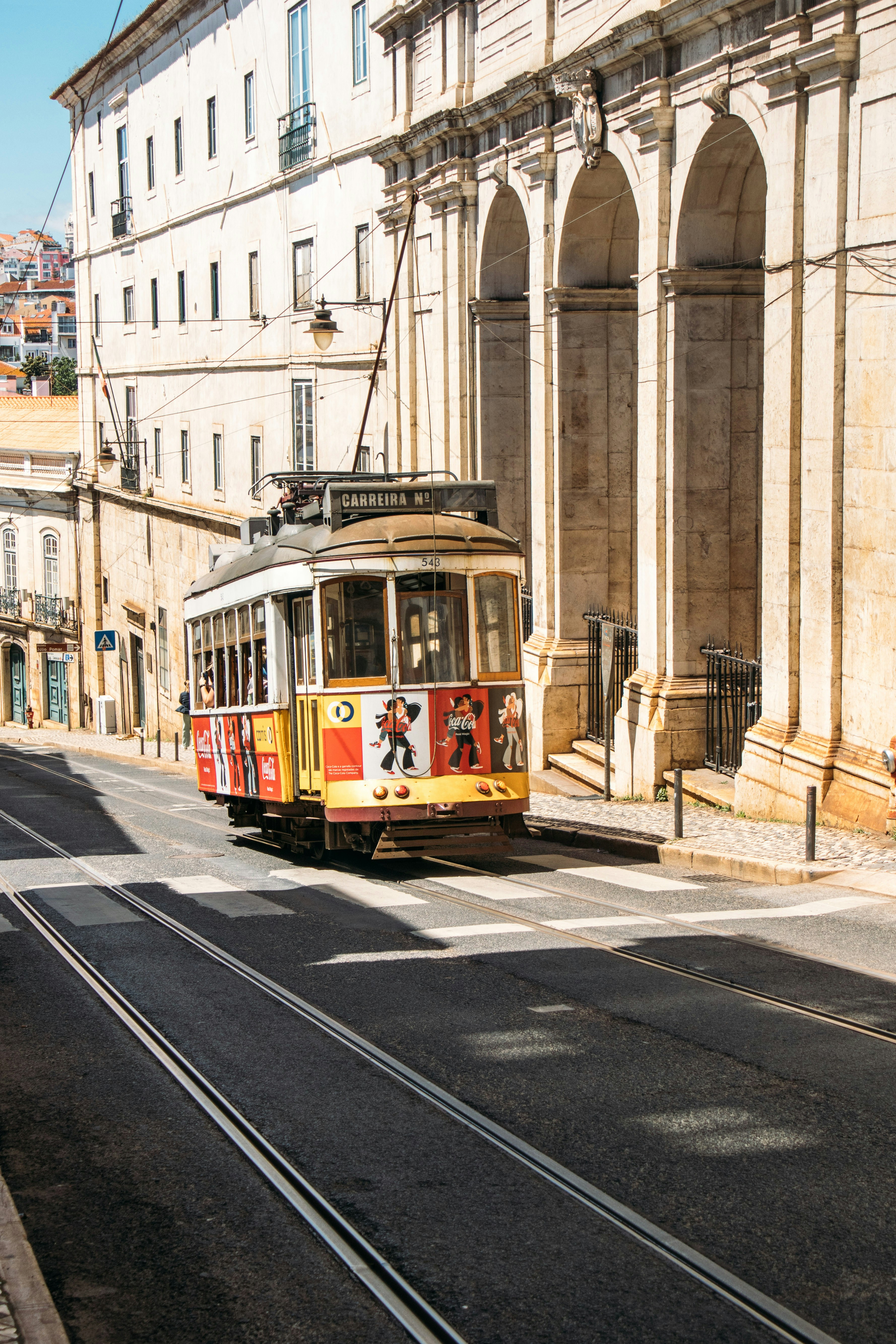 Historic Tram Rolling Past Ancient Columns