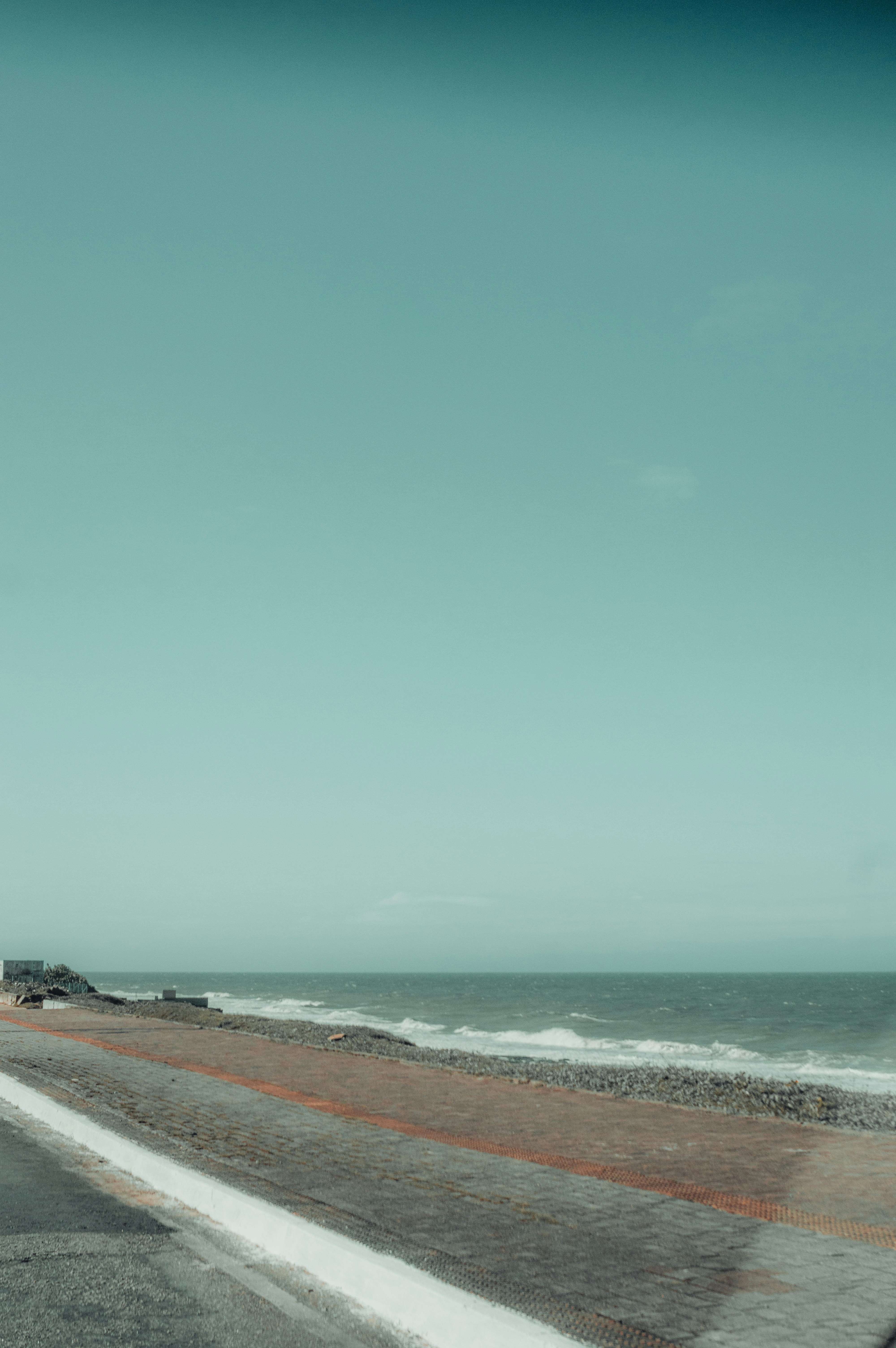 Coastal Roadside Quiet: A Sea-Waded Path Under a Wide Sky