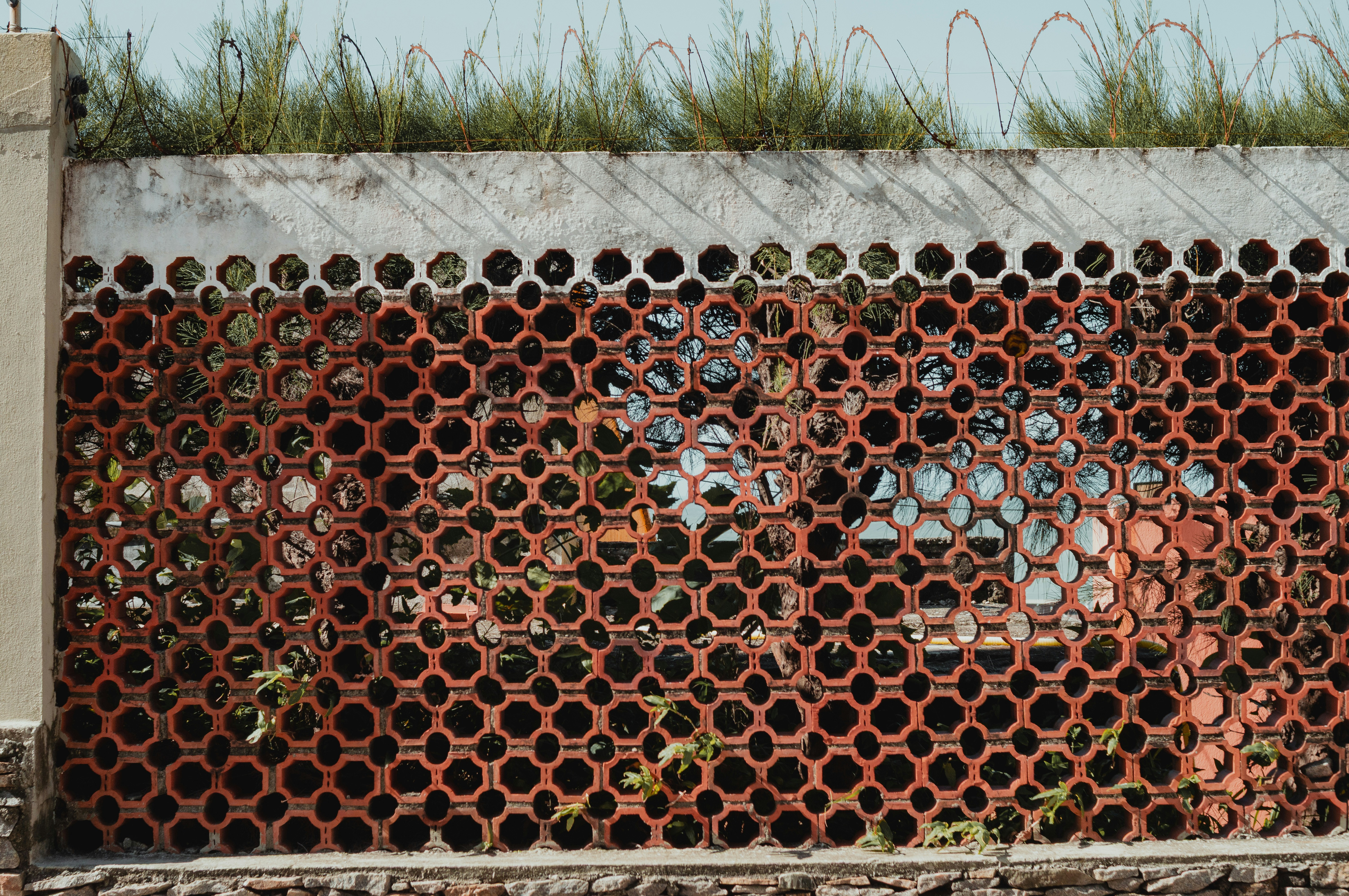 Concrete Barrier with Circular Vent Openings and Hidden Figures