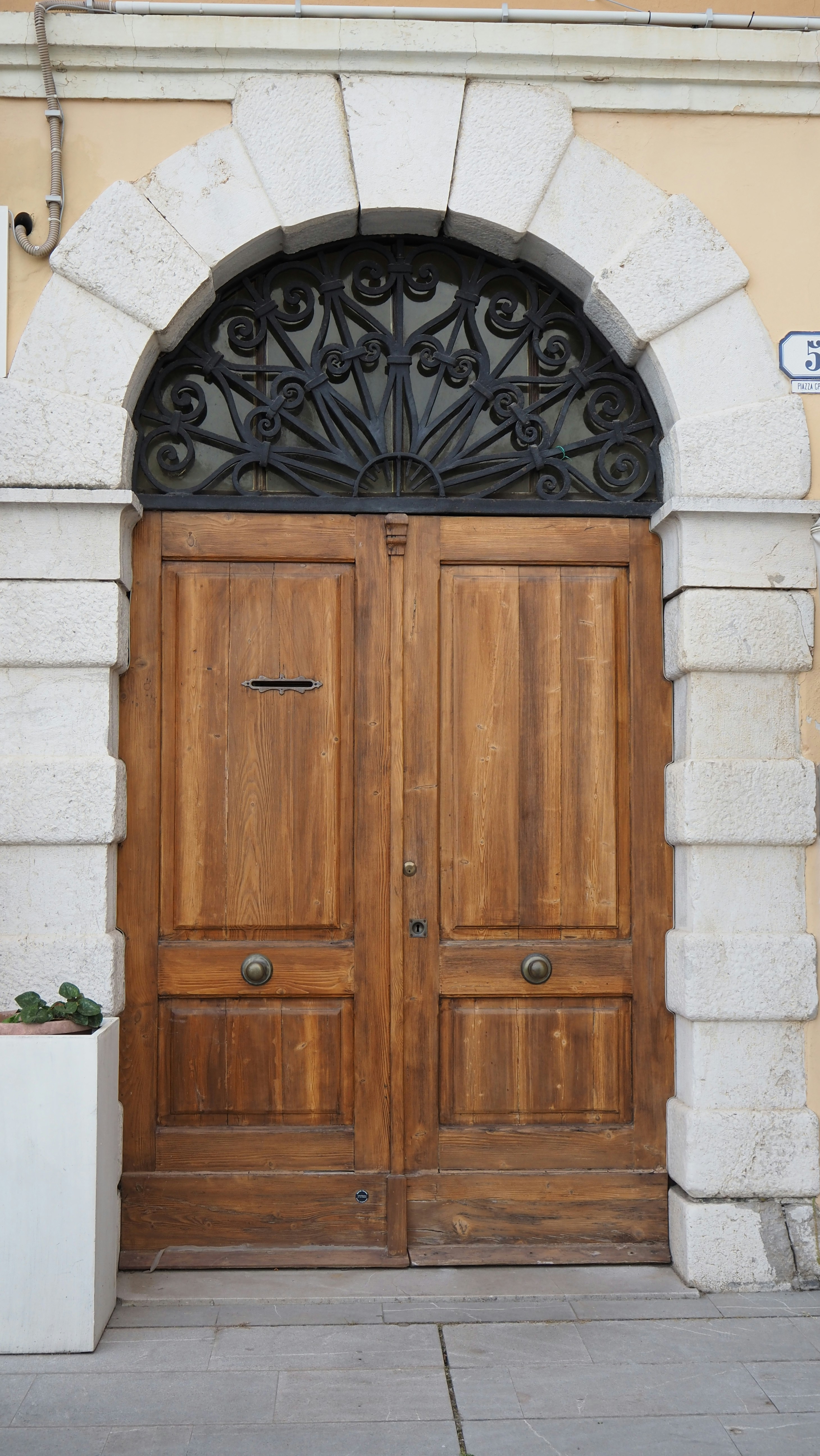 Weathered doorway with carved iron fanlight and warm timber panels
