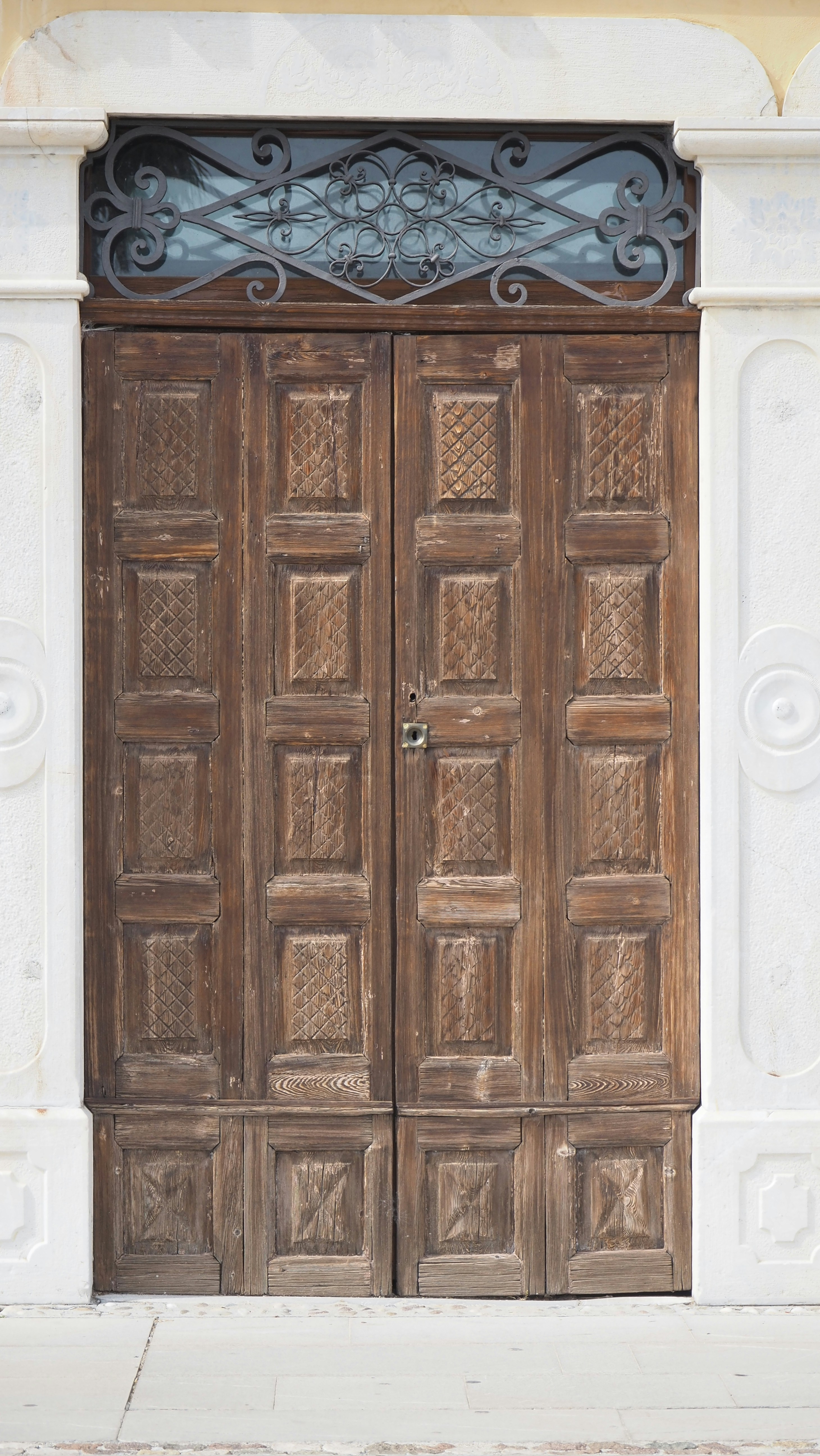 Weathered doorway: carved panels and ironwork framing a silent entry