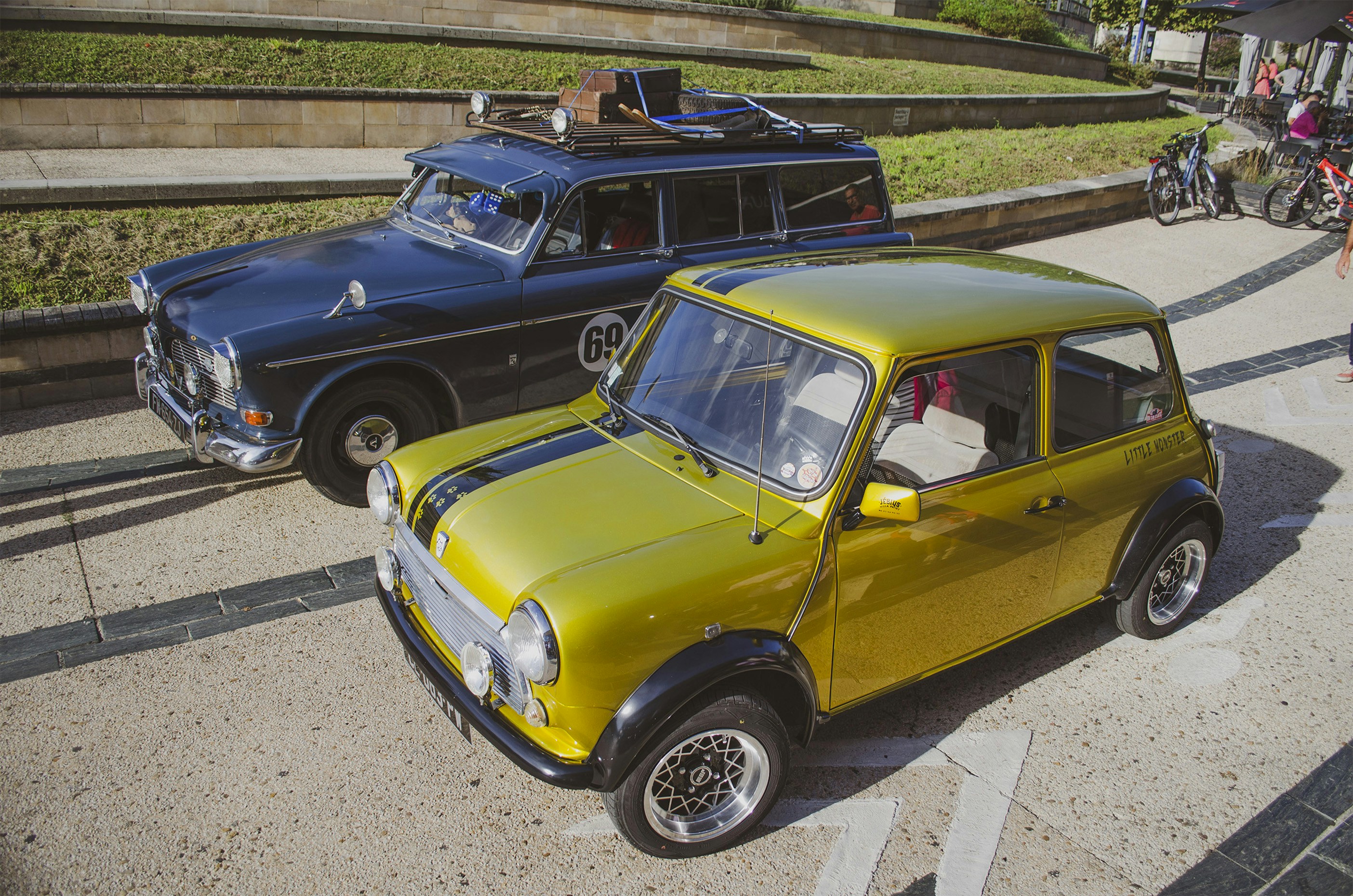 Yellow Mini Coupe Leading the Line of Classic Cars