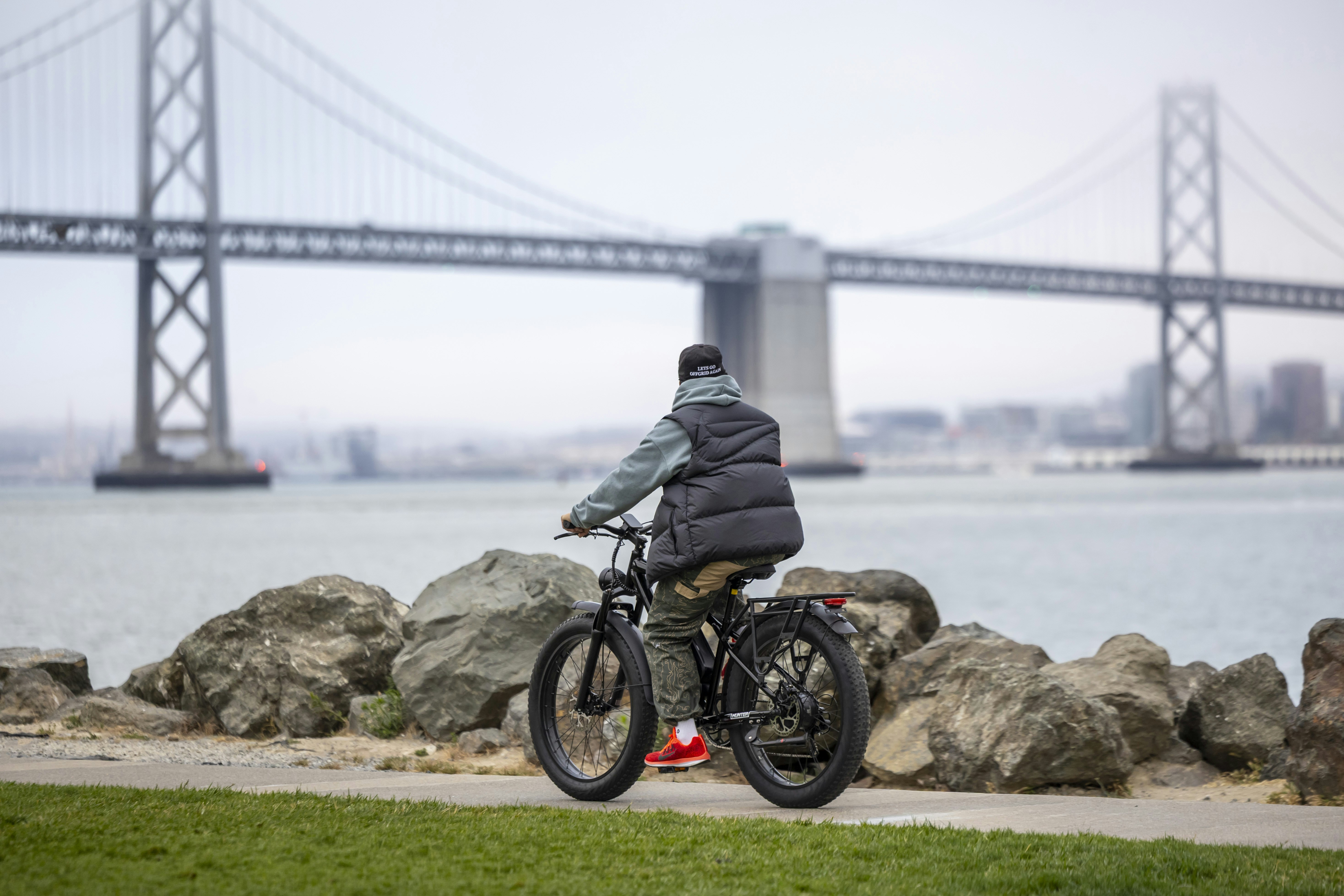 Ridge by the Water: Cyclist Pauses Before the Bay Bridge