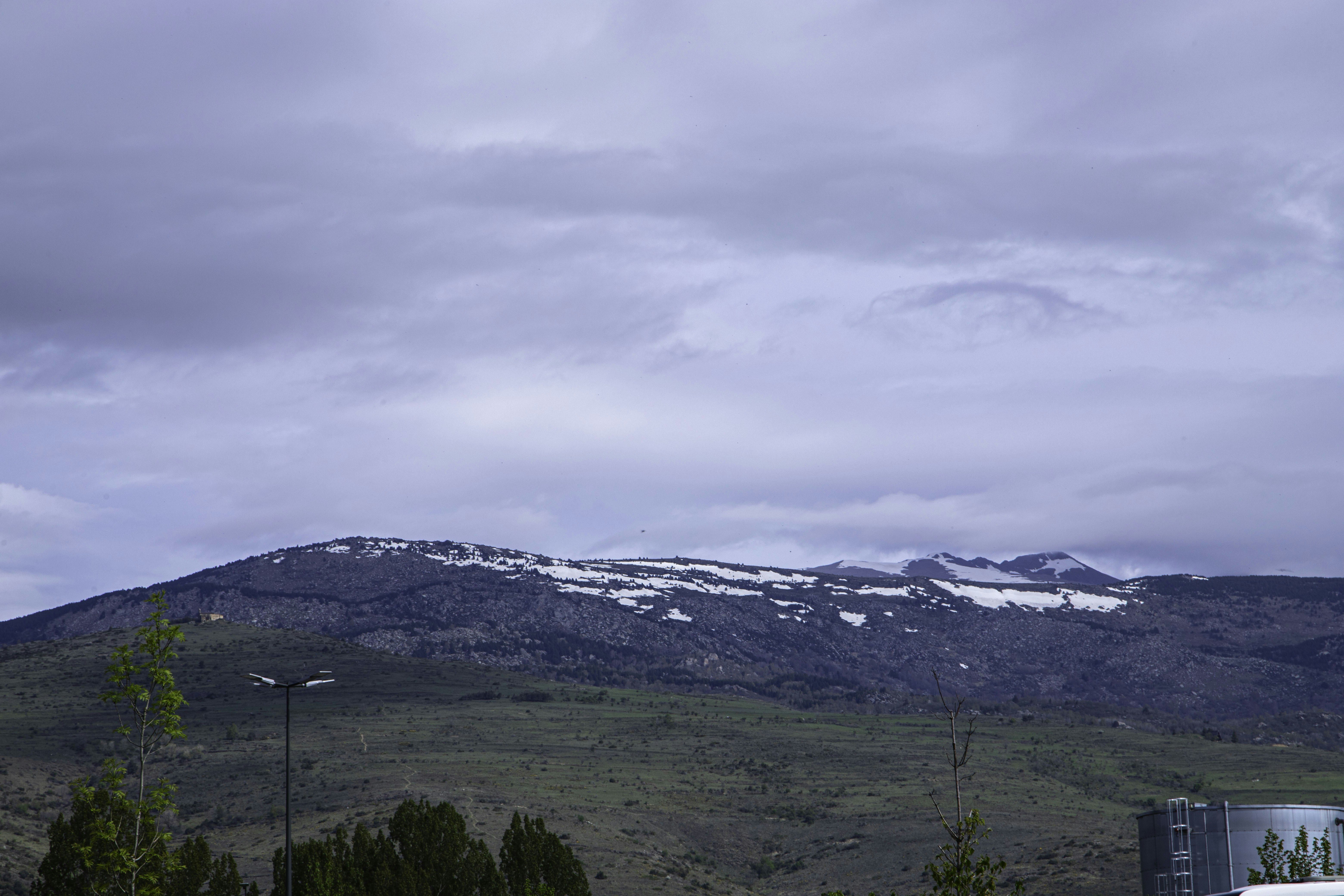 Snow-dusted ridge under a calm, cloudy sky