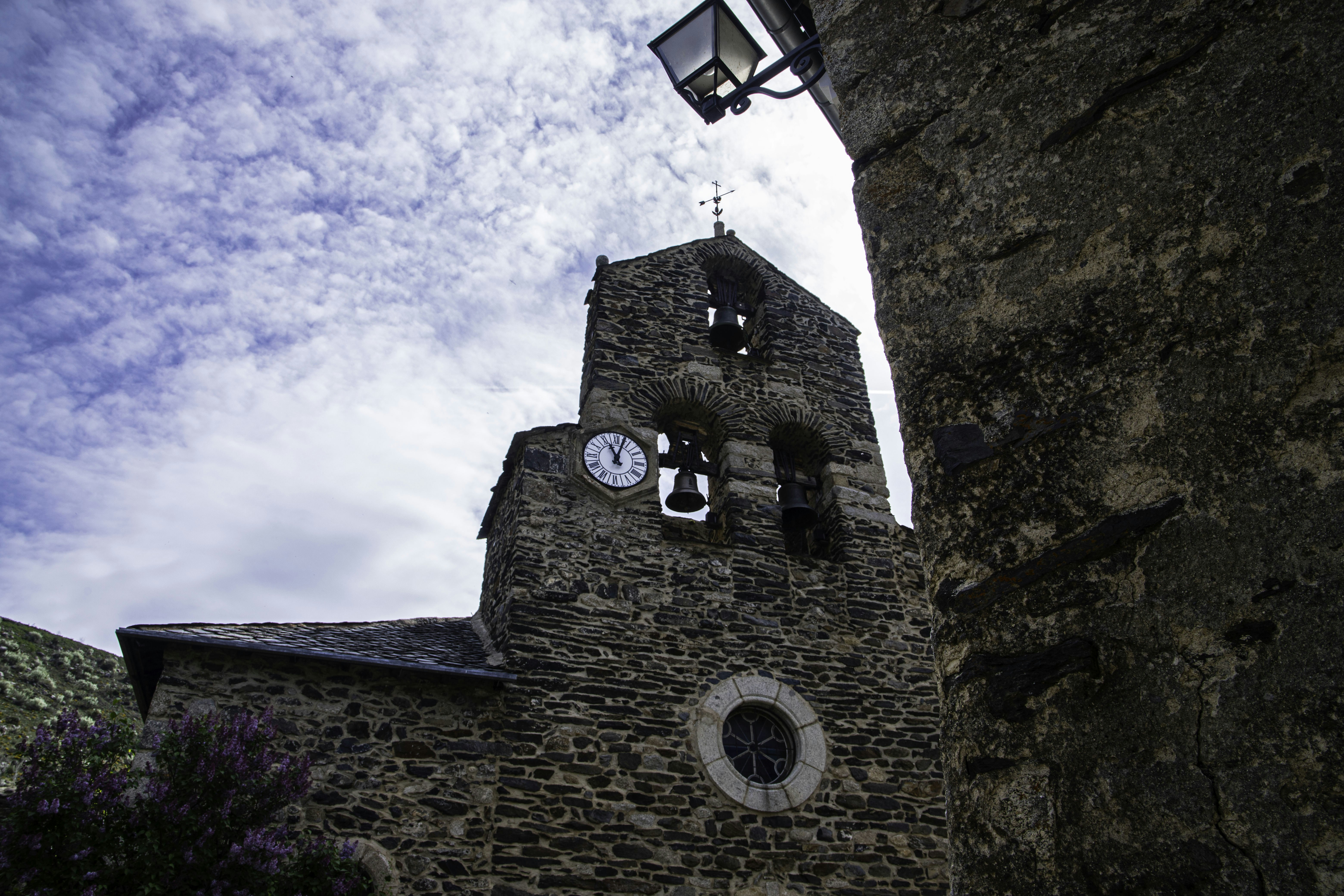 Ancient stone bell tower under a bright sky