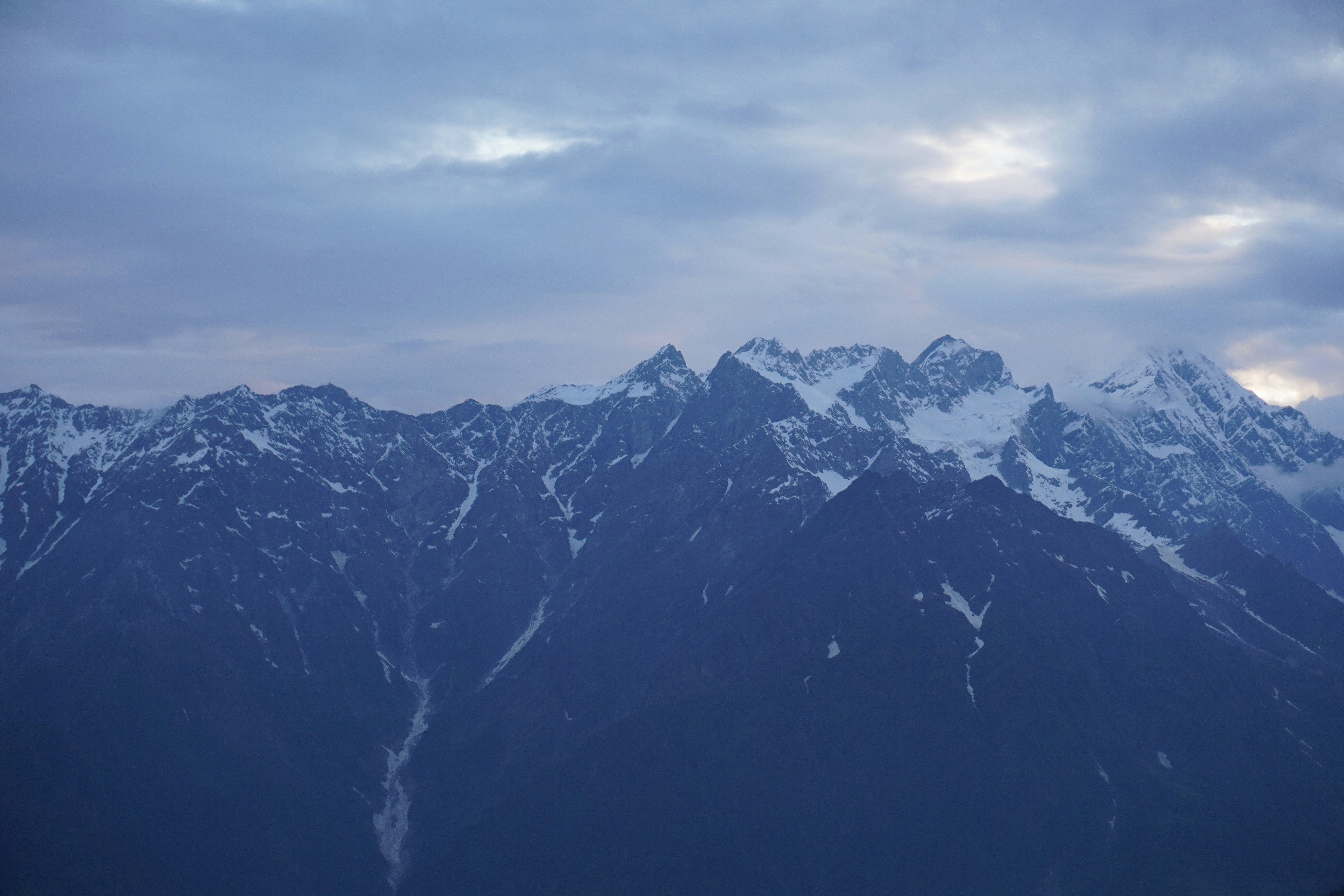 Snow-capped skyline under a moody alpine sky
