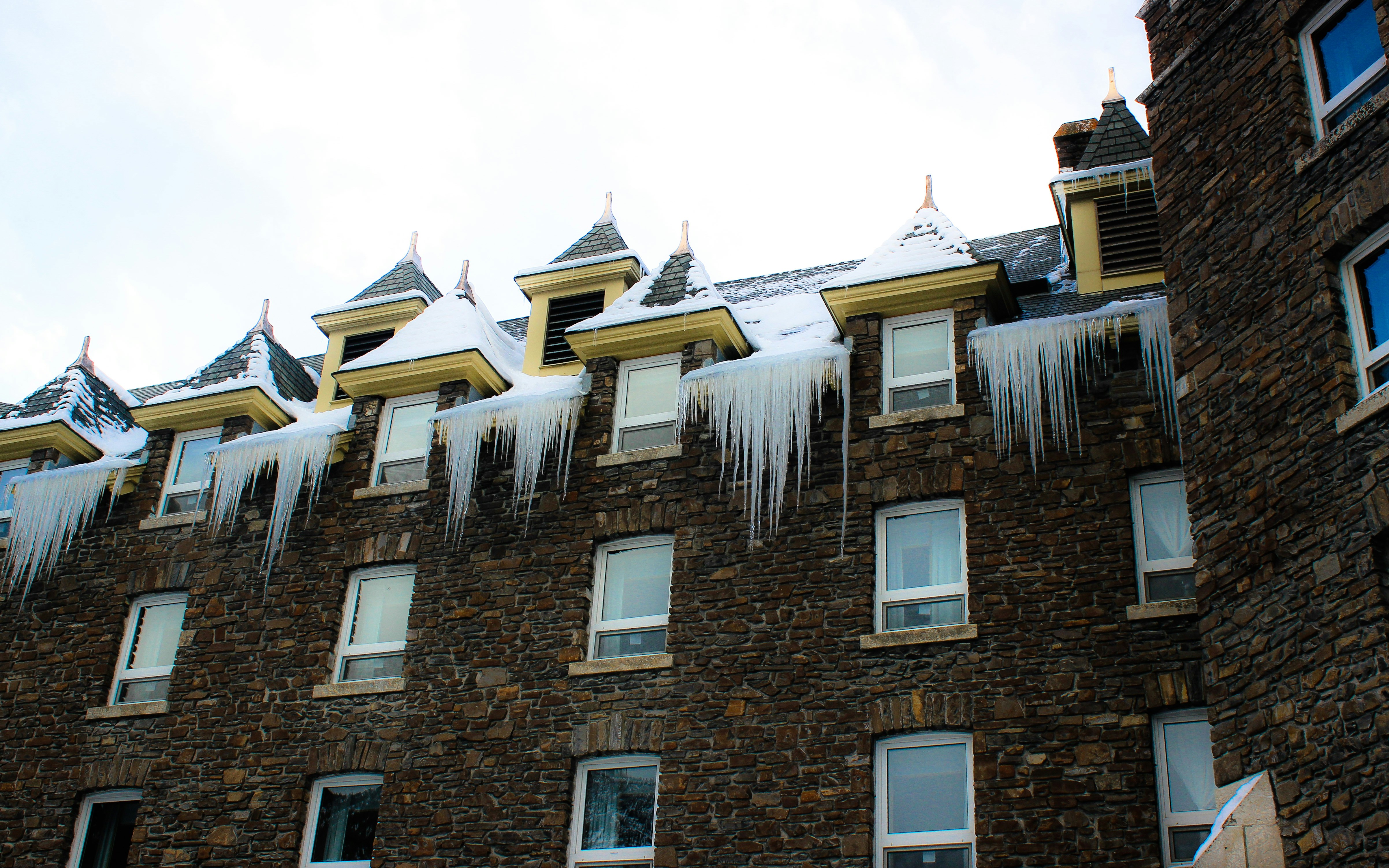 Icicles over a brick townhouse: winter rooftop details