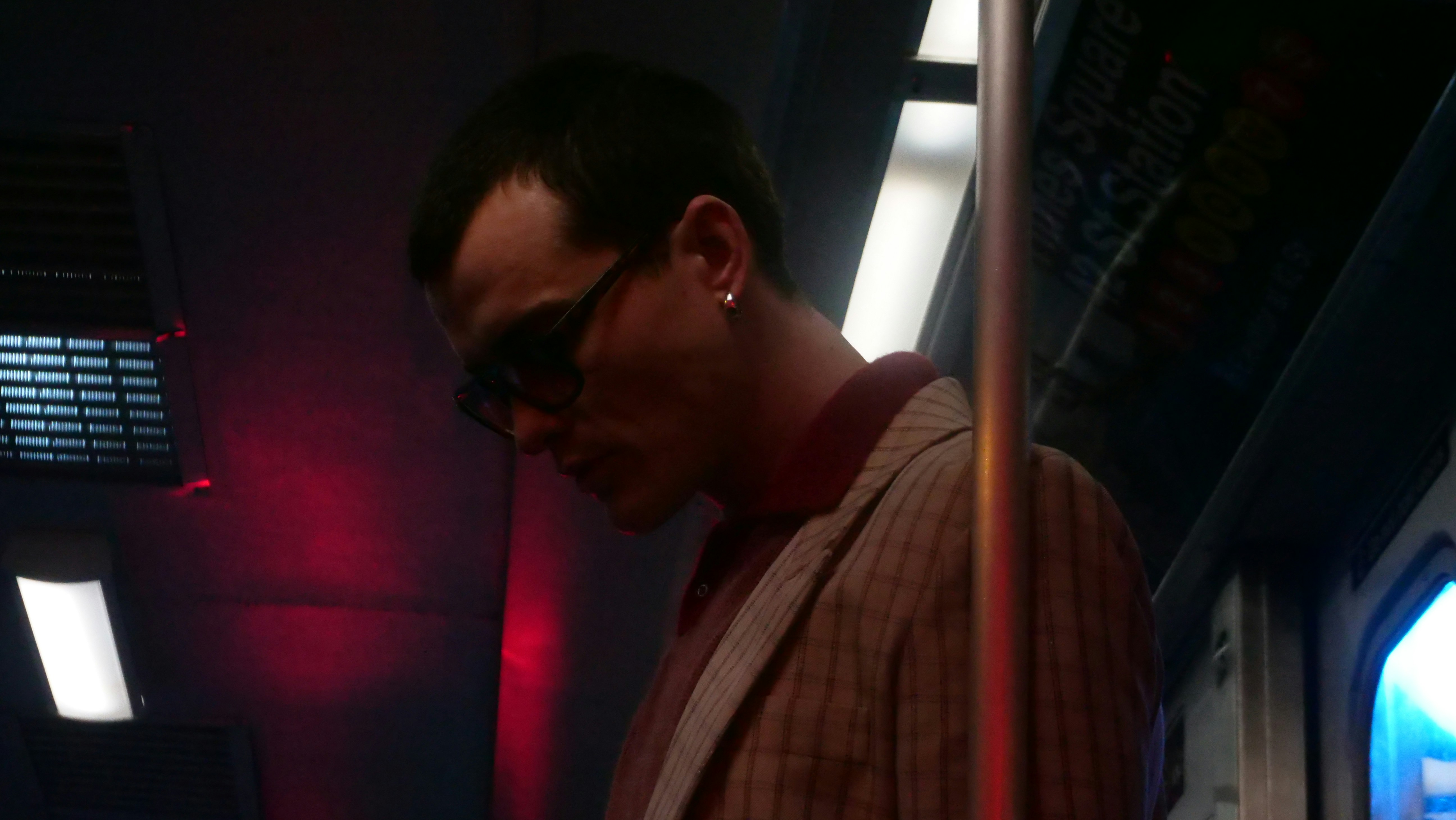 Neon-lit commuter silhouette in a subway car