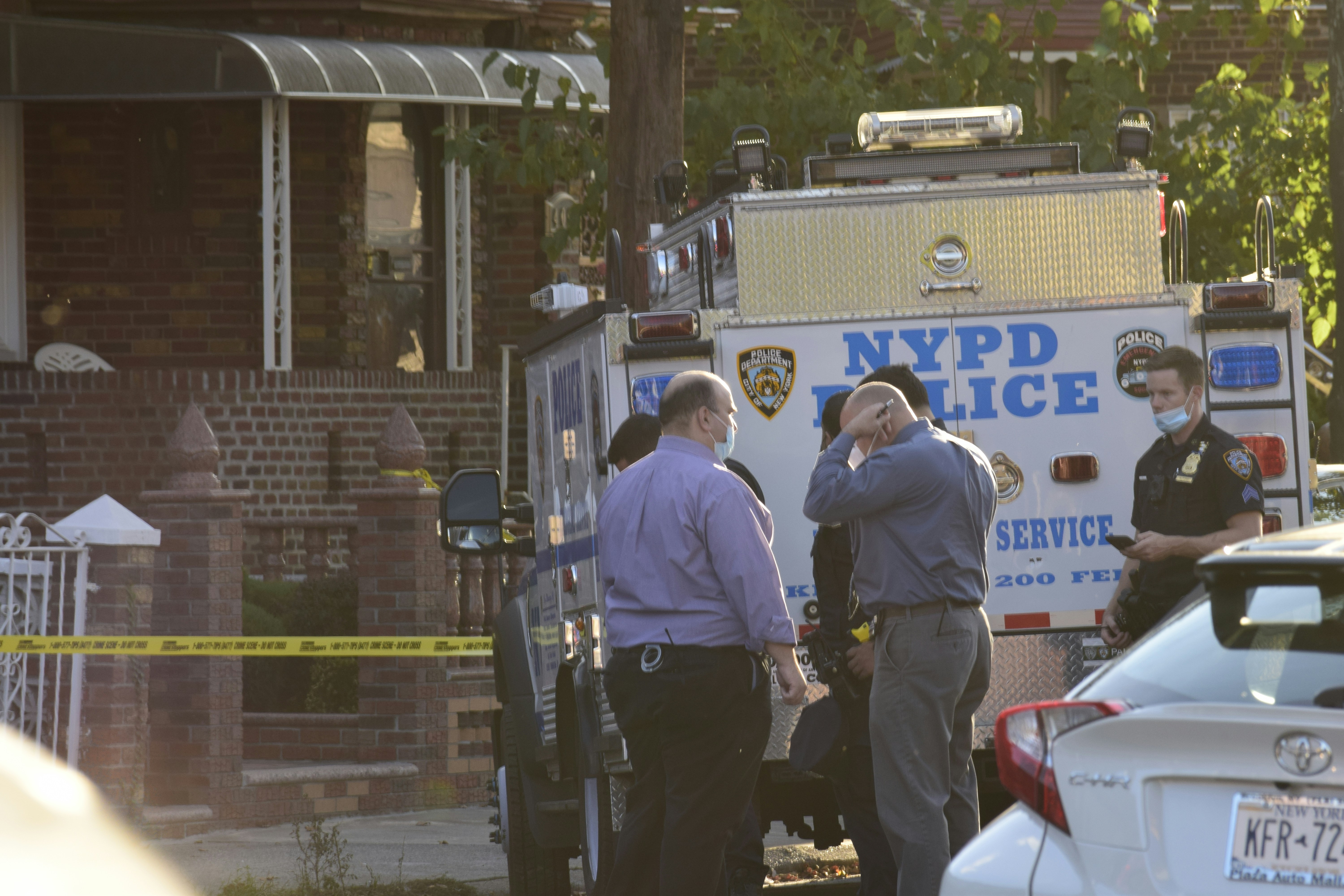 Police Incident Scene: Officers and NYPD Vehicle at Distant Crime Scene