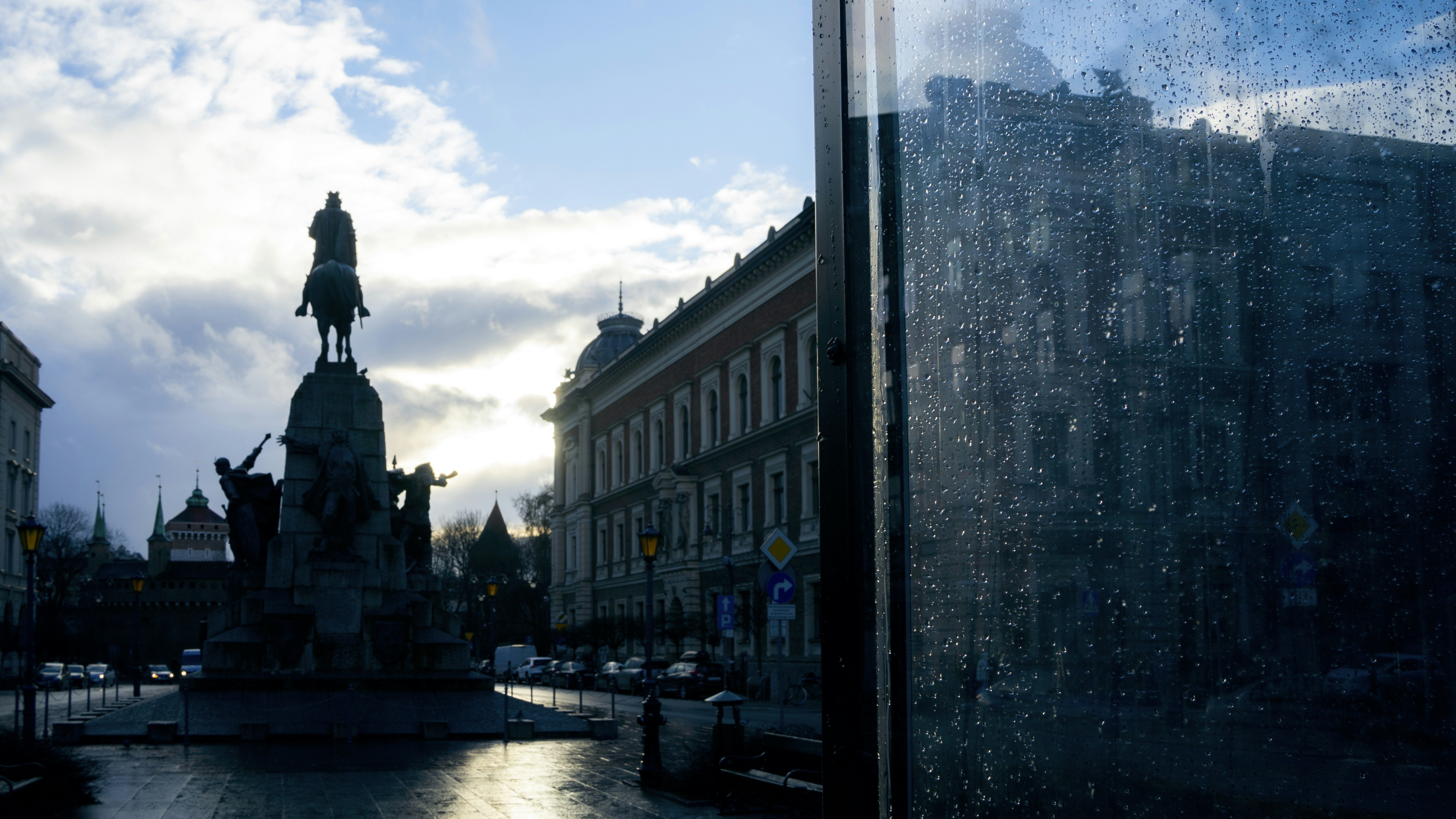 Statue Silhouette at a Rain-Speckled City Edge