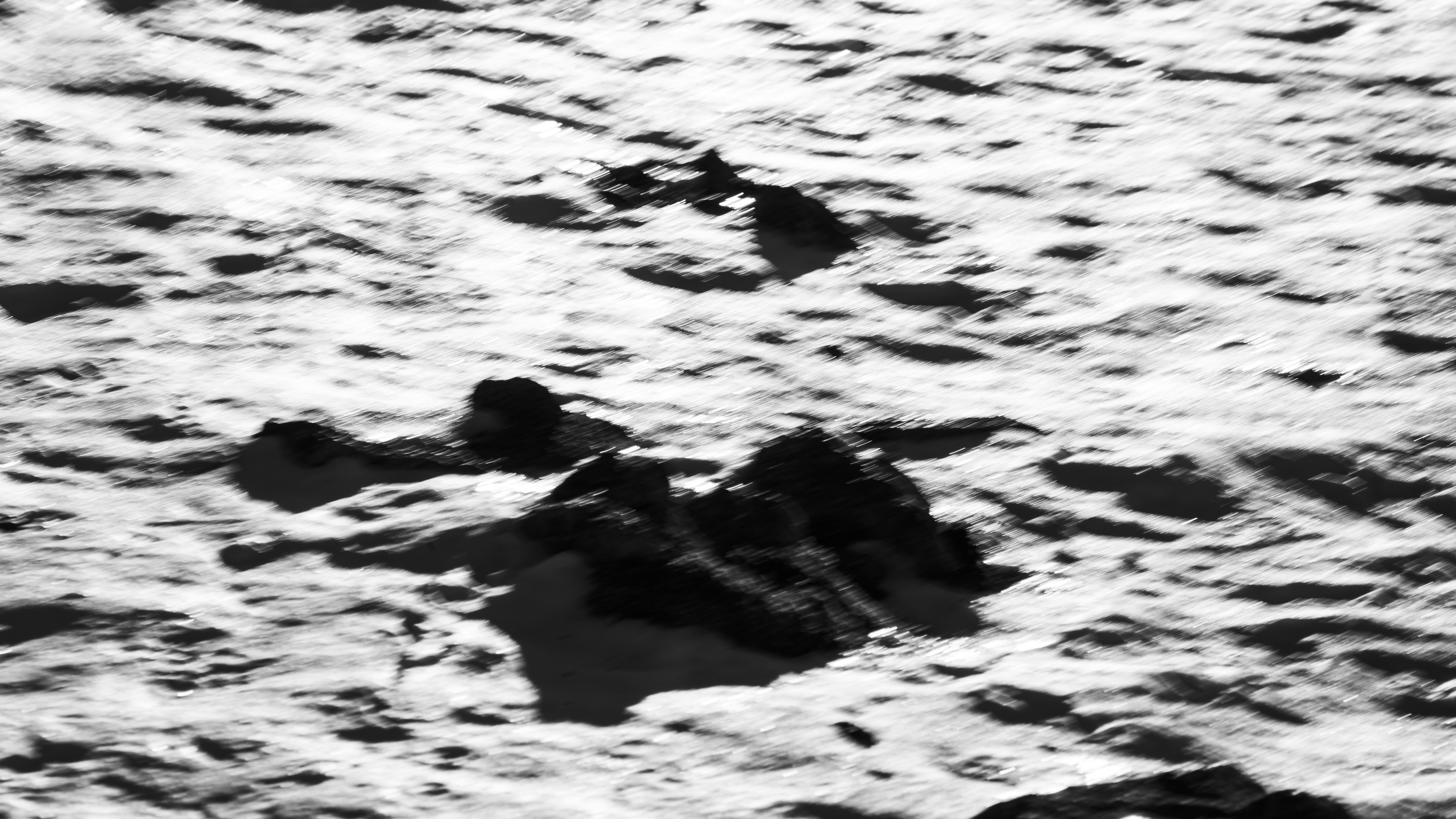 Silhouetted Landscape of Wind-ruffled Rocks in High-Contrast Sea Foam