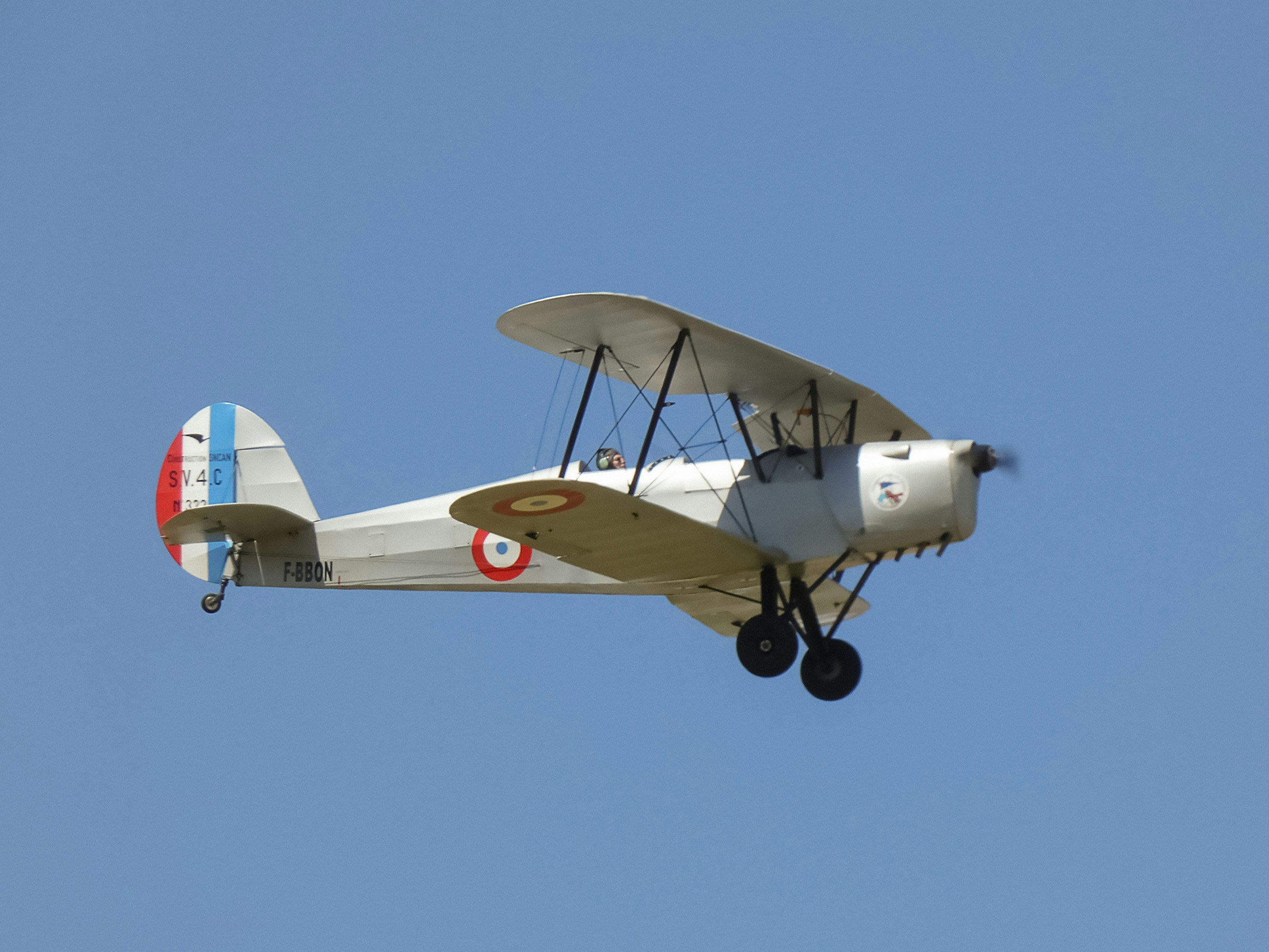 Historic biplane in ascent: vintage blue-sky flight