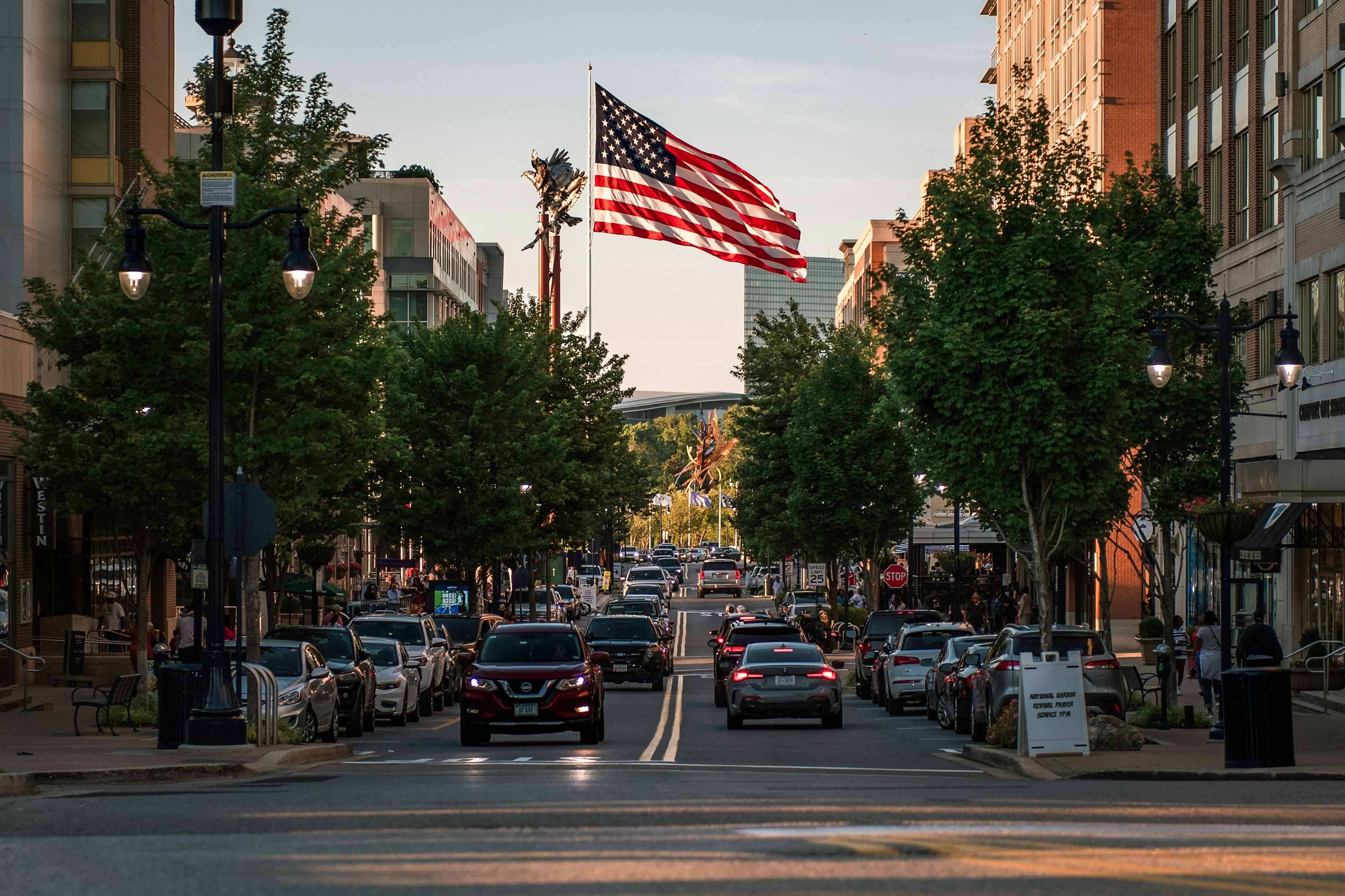Flag Over the City Street: A Quiet Moment Beneath the Moving Traffic
