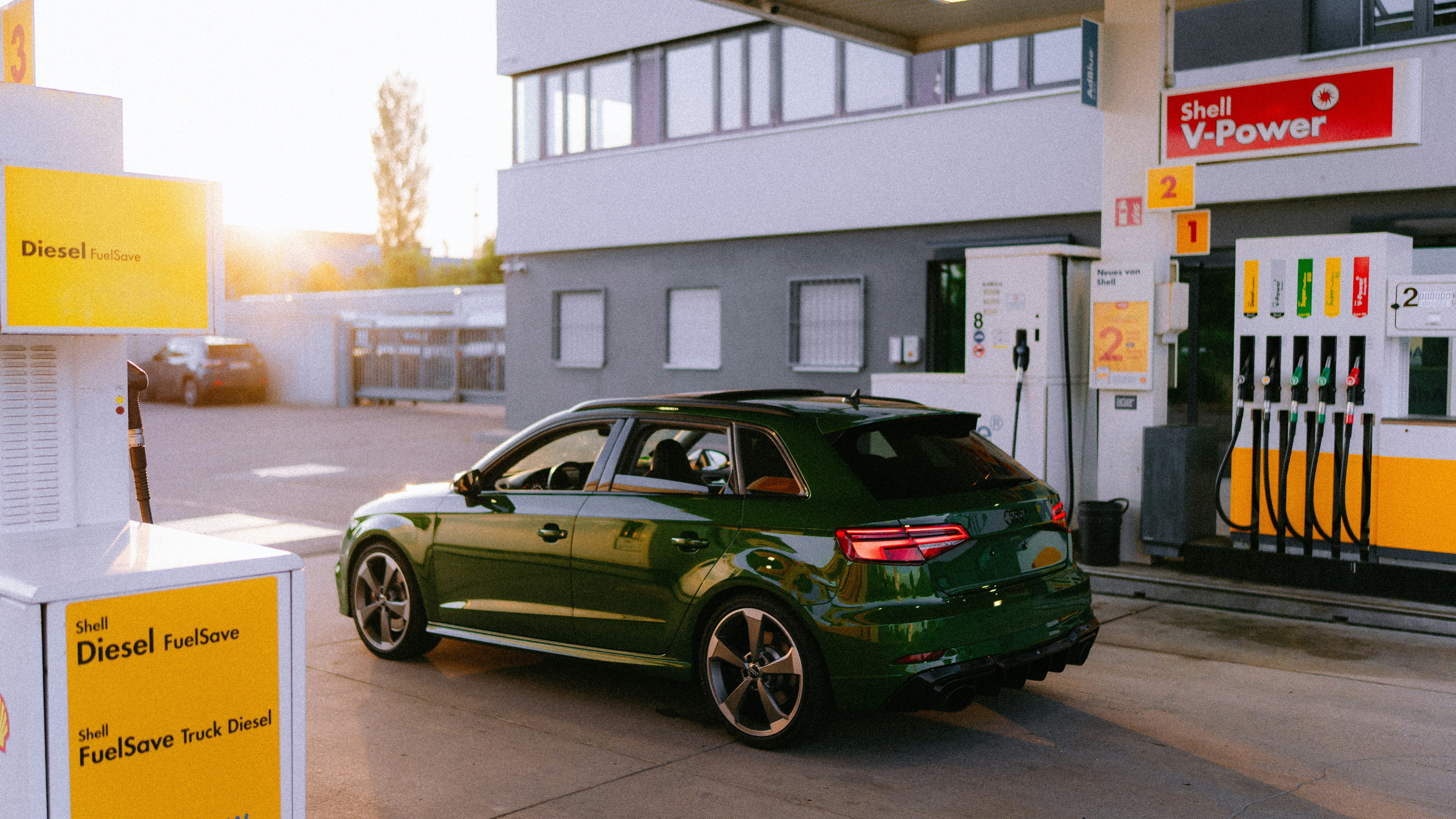Green SUV at a Sunlit Gas Station: Quiet Power by the Pumps