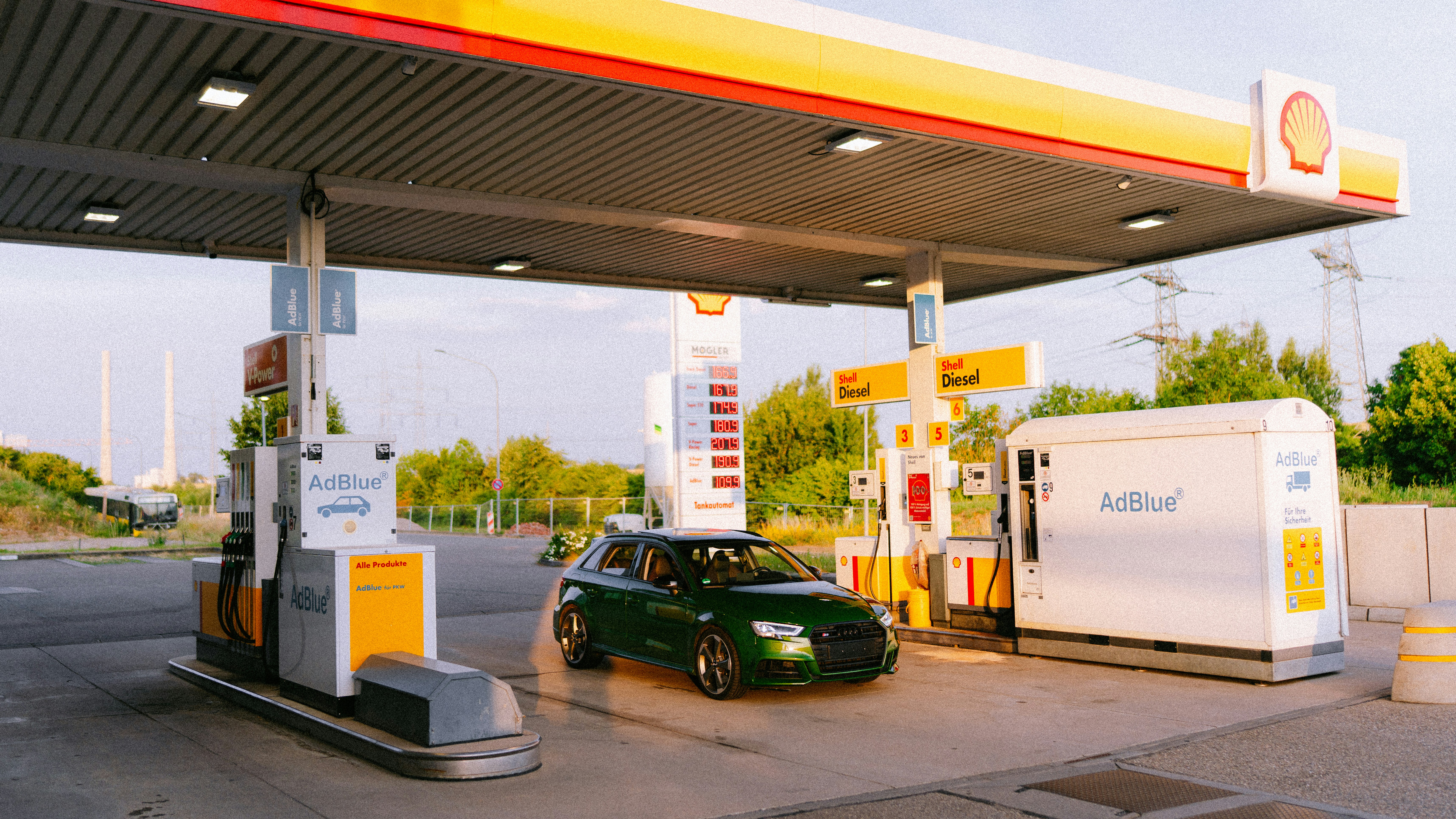 Green Hatchback at a Sunny Shell Station
