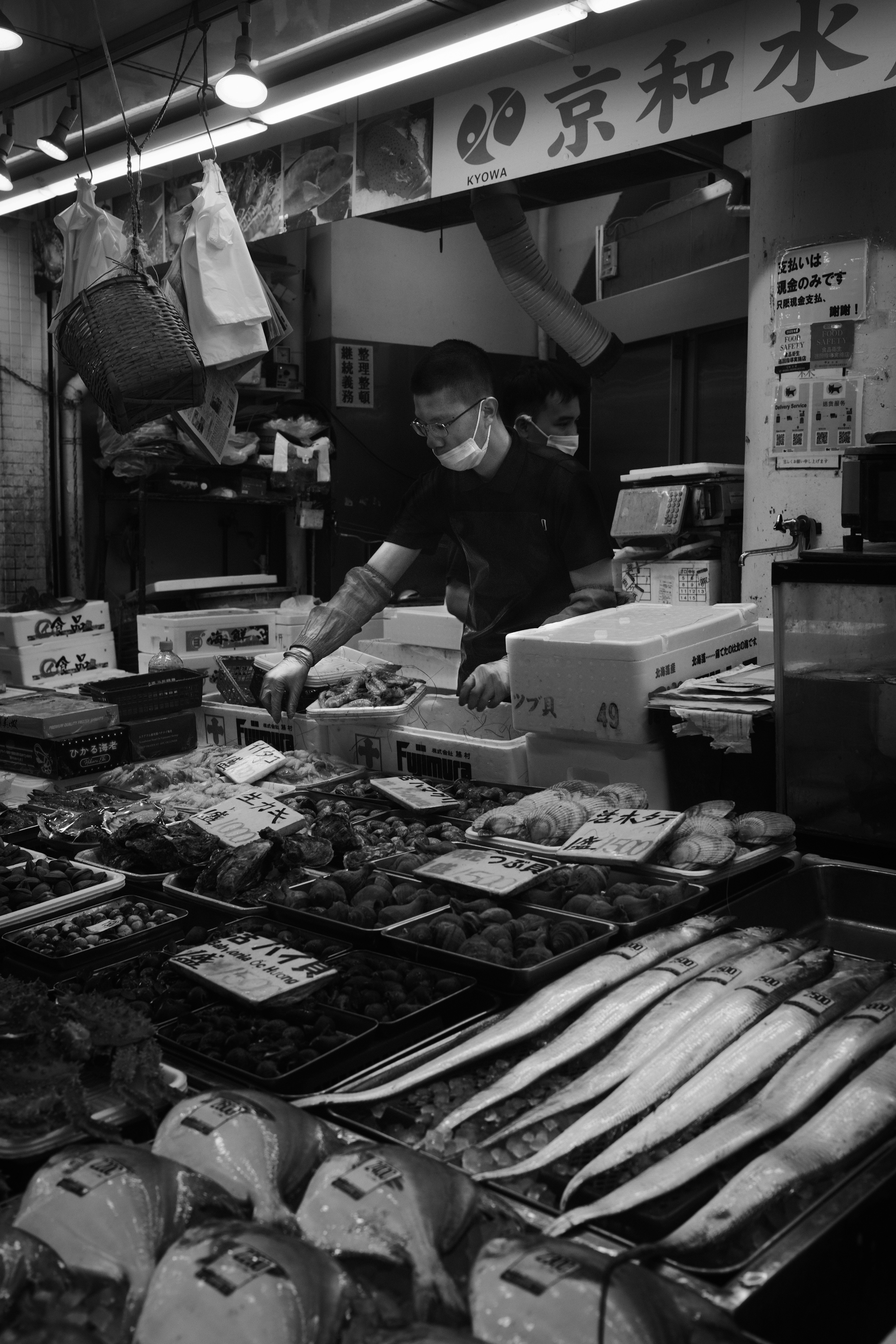 Market Vigil: A Vendor Sorts Fresh Produce Under Fluorescent Glow