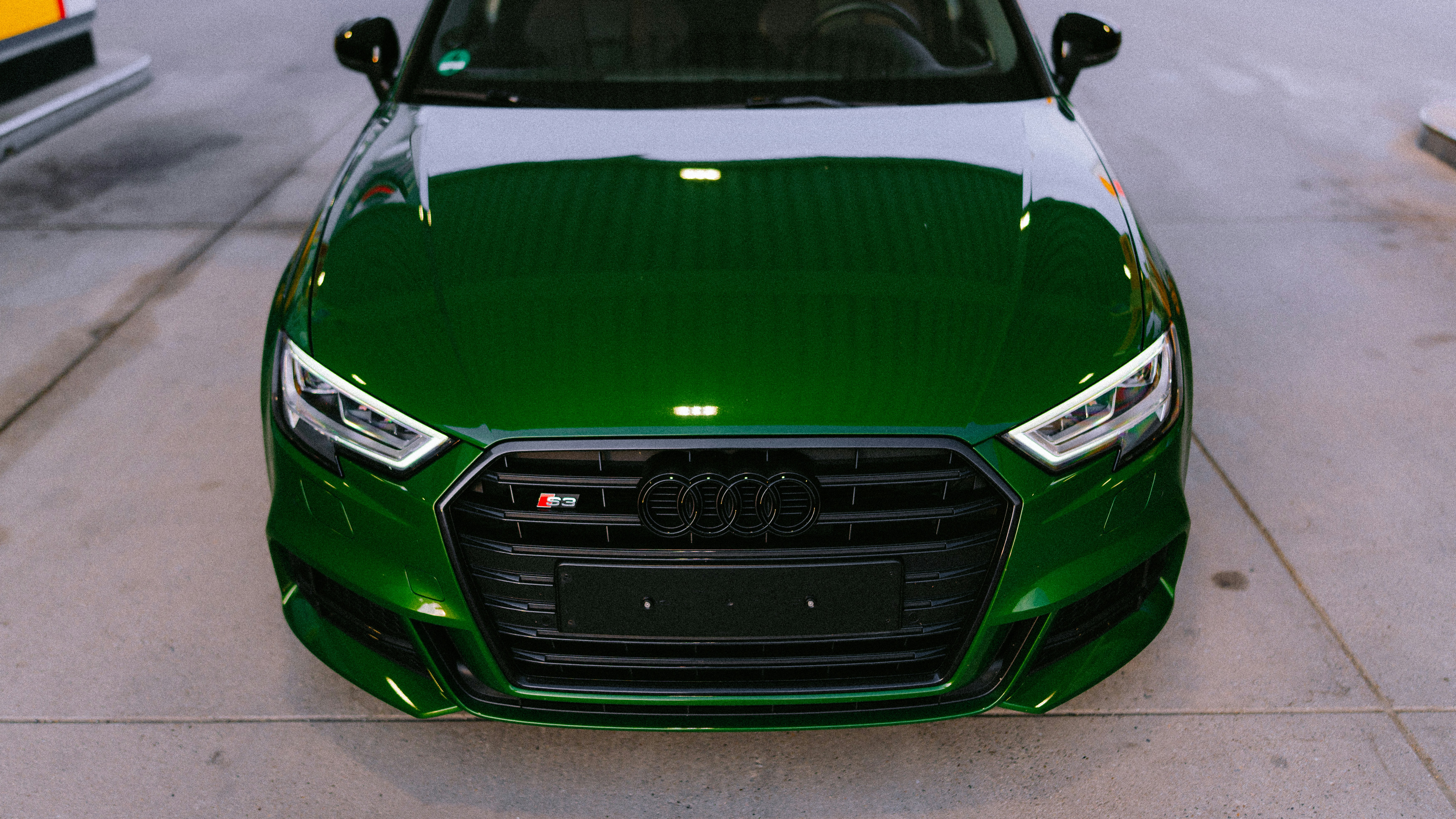 Emerald Audi Gaze: A Front-View Portrait in a Quiet Parking