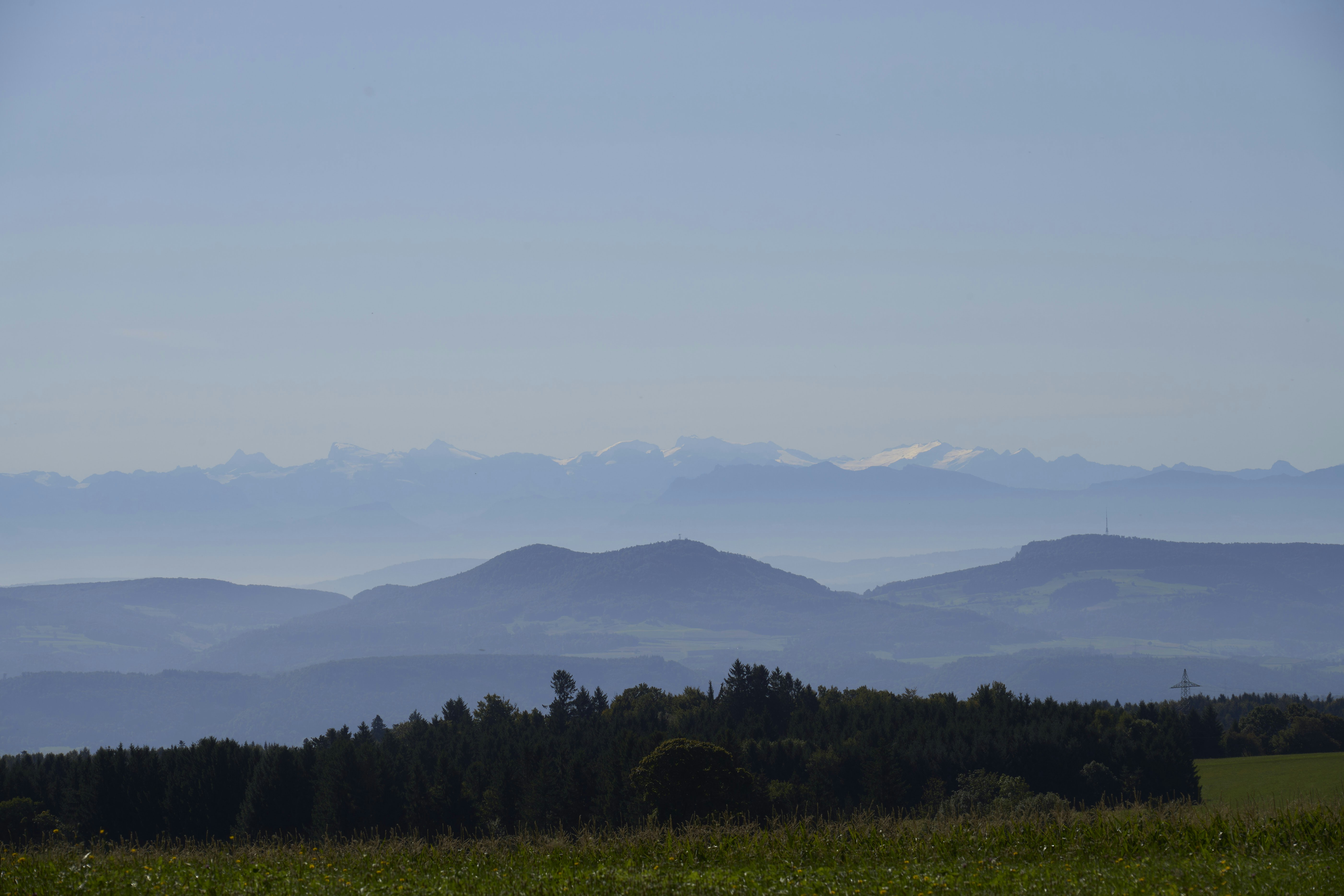 Horizon Layers: Rolling Hills Fading into Alpine Light