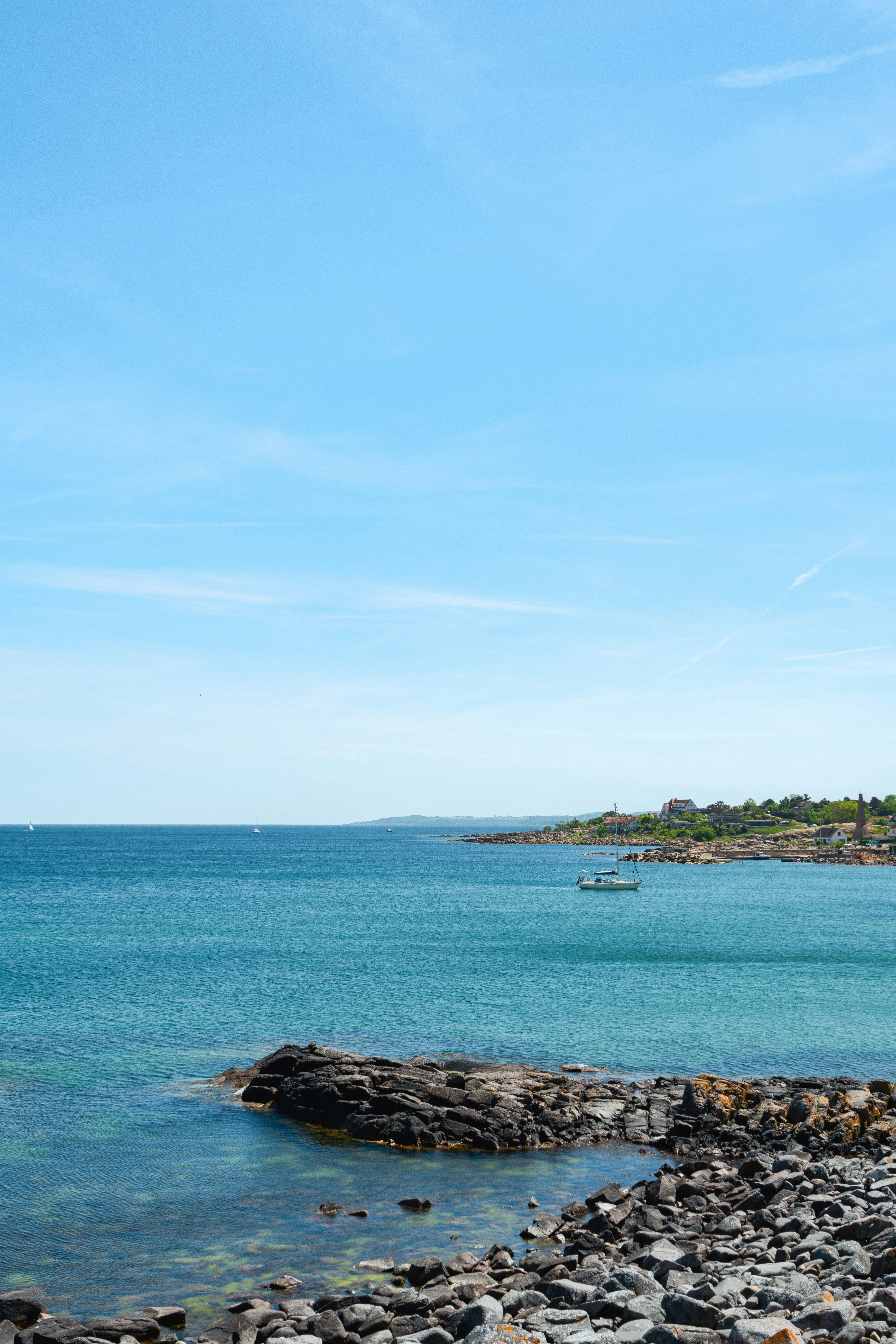 Coastal Horizon: Quiet Boat at the Edge of Coastal Rocks