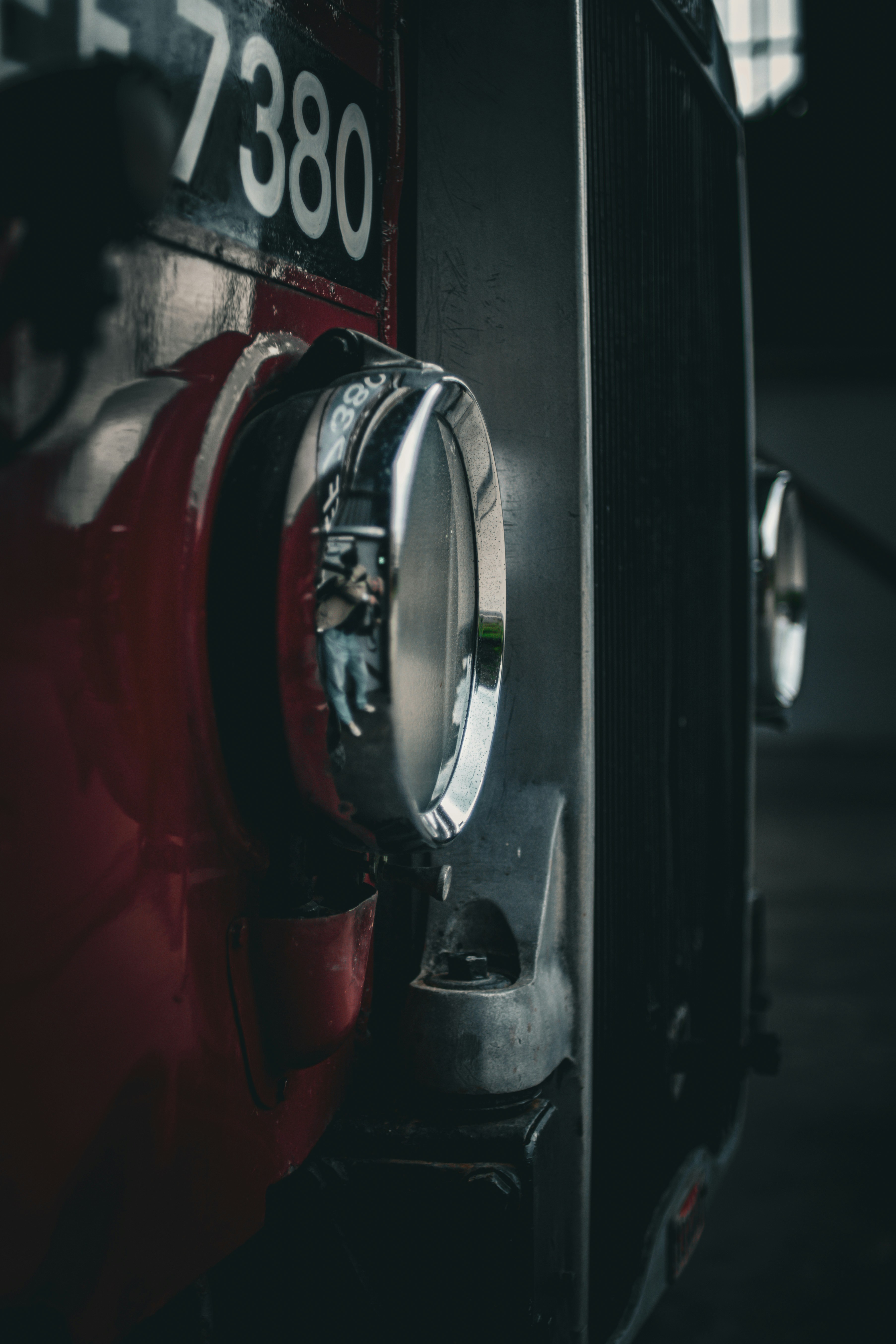 Close-up of a vintage locomotive detail revealing its chrome dial and red body