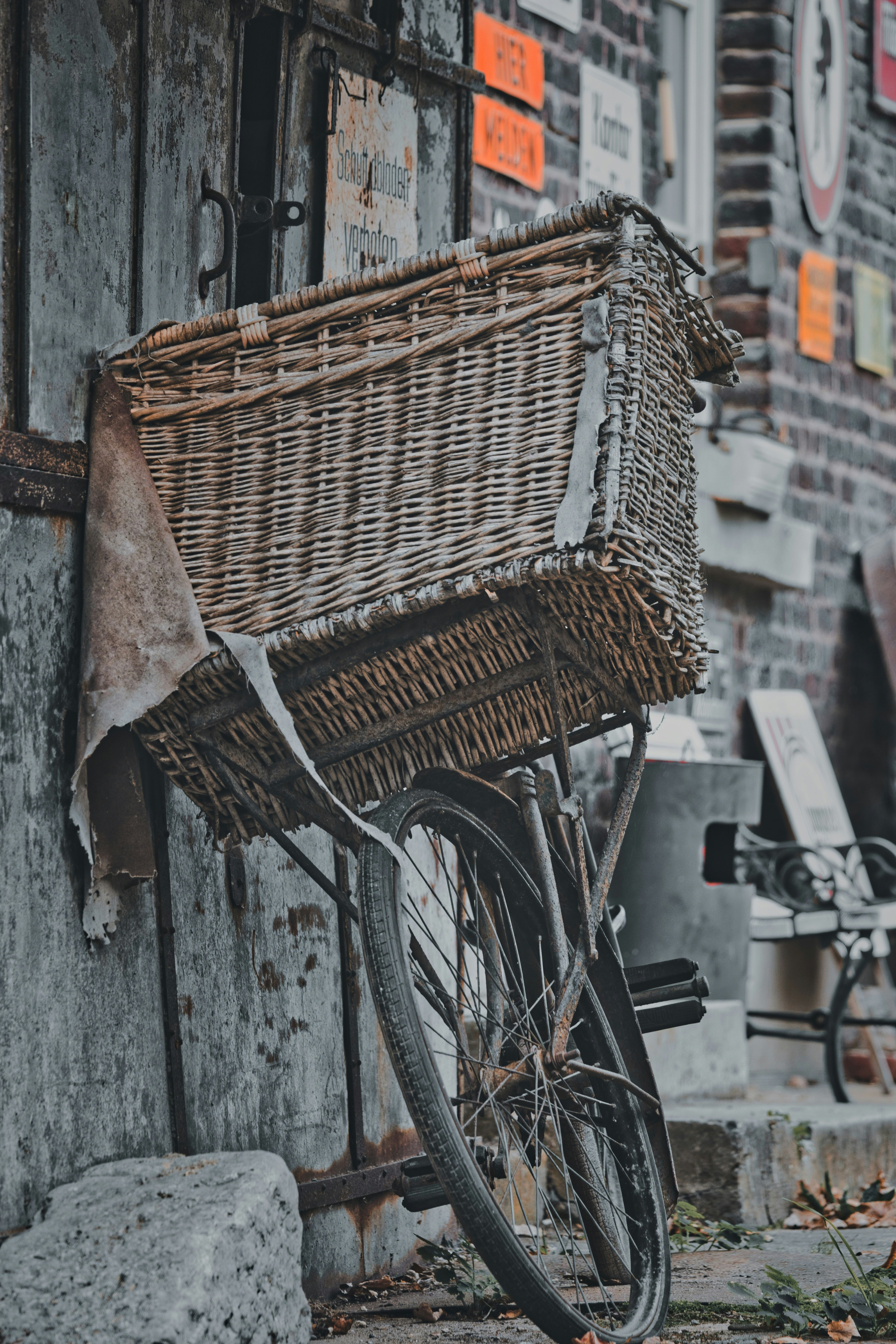 Basket on a weathered bike leaning against a brick wall