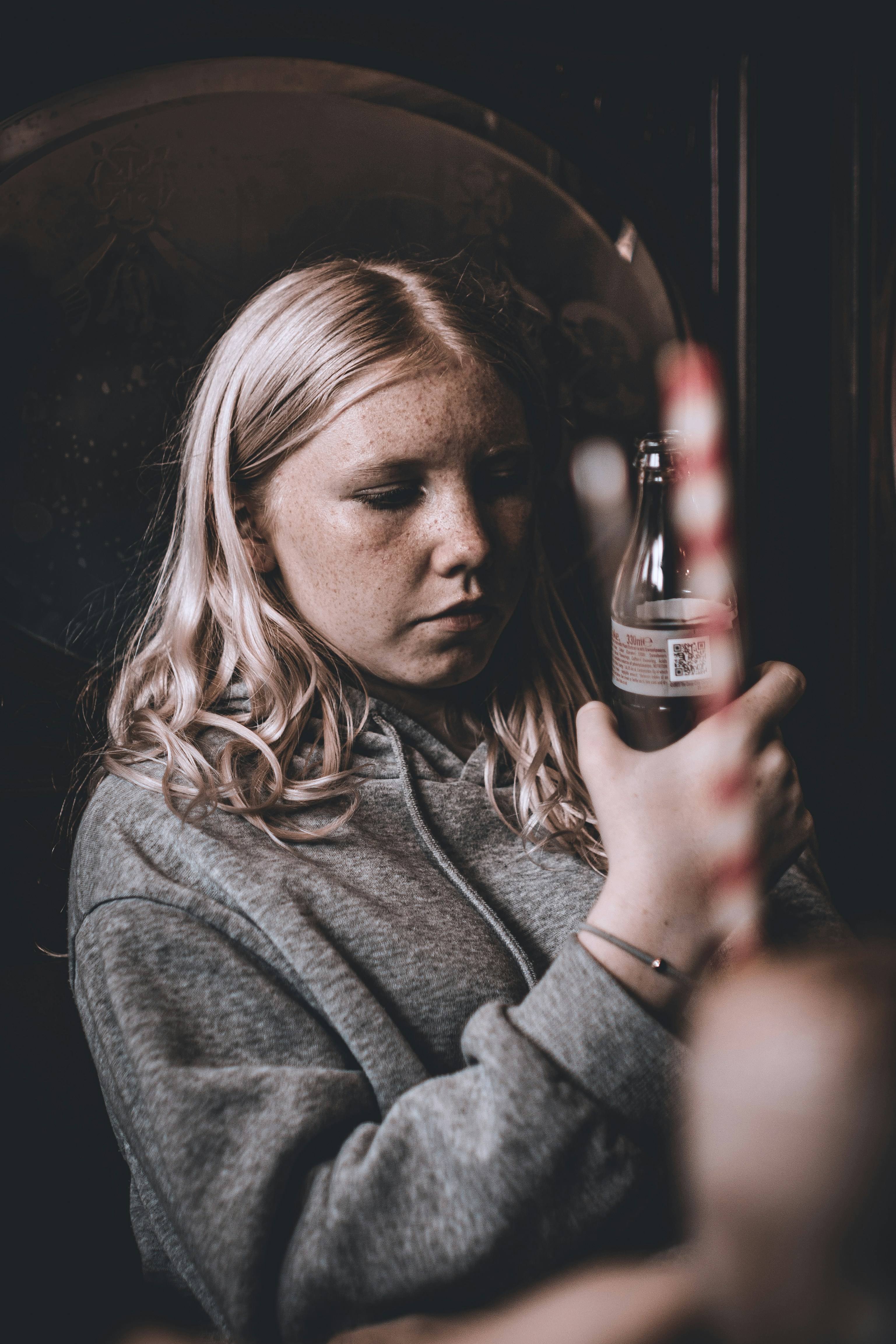 Soft Focus in a Quiet Moment: A Teen in a Hoodie with a Bottle