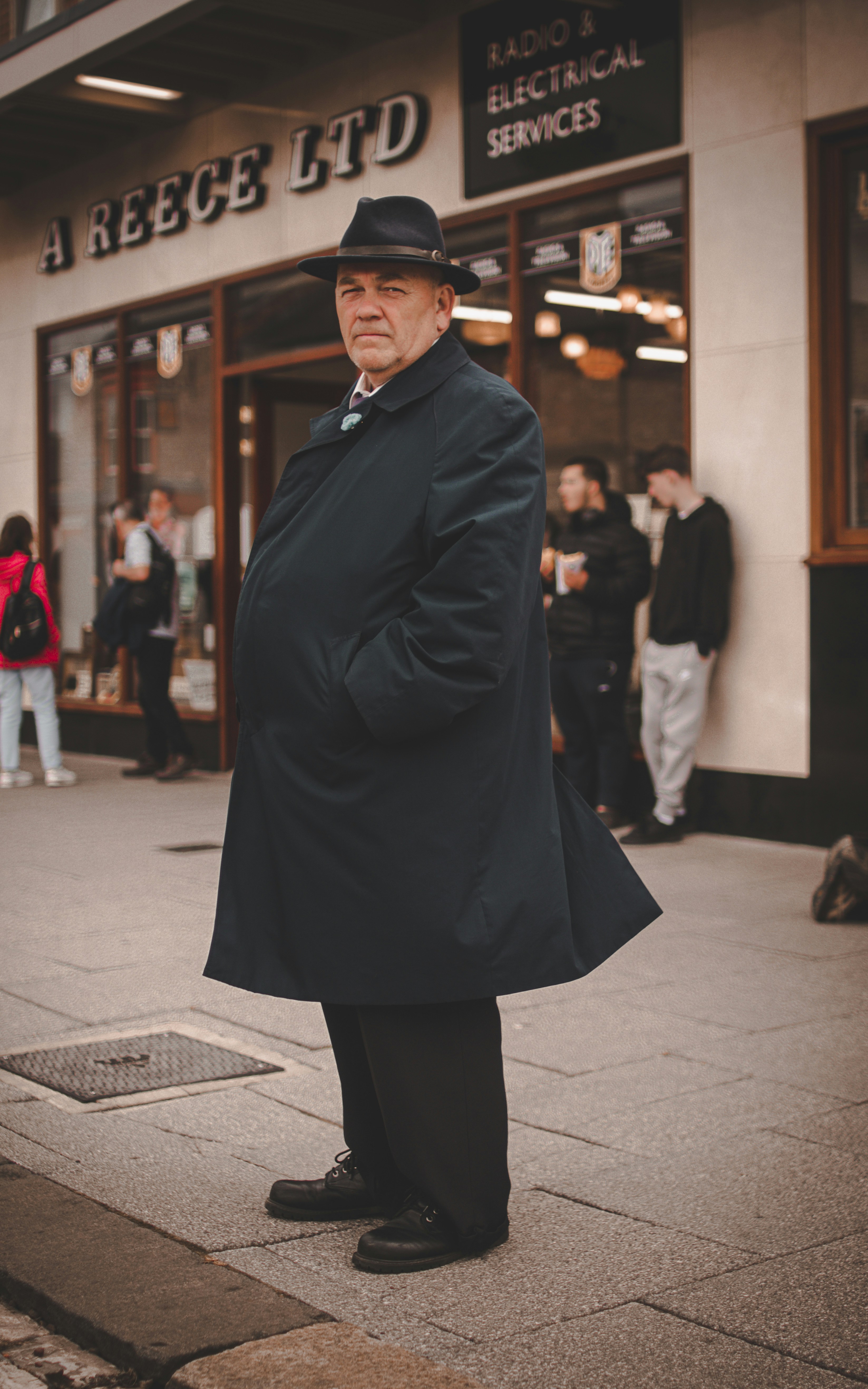 The Trench-Coat Sentinel on a Bustling Street