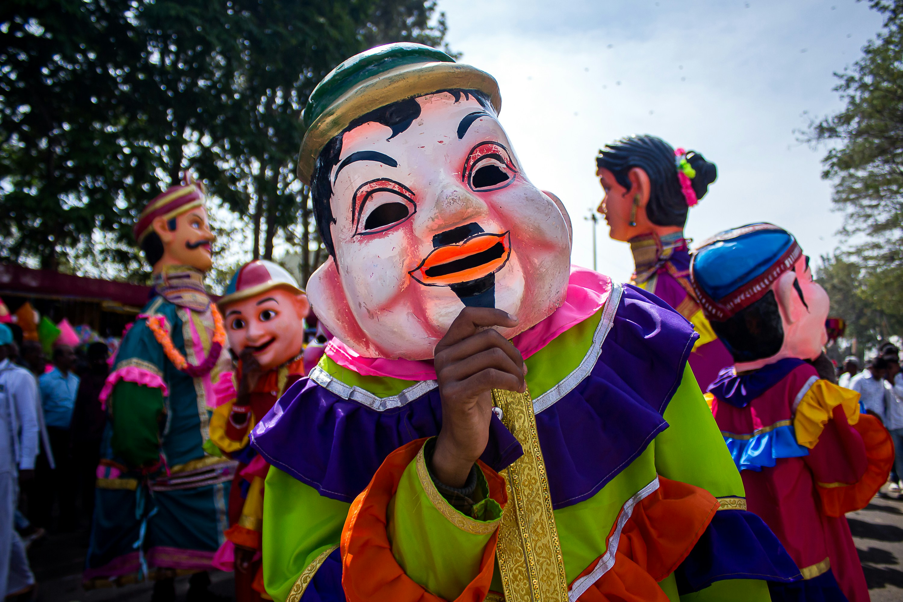 Mask of the Carnival Jester Reaches Toward the Crowd