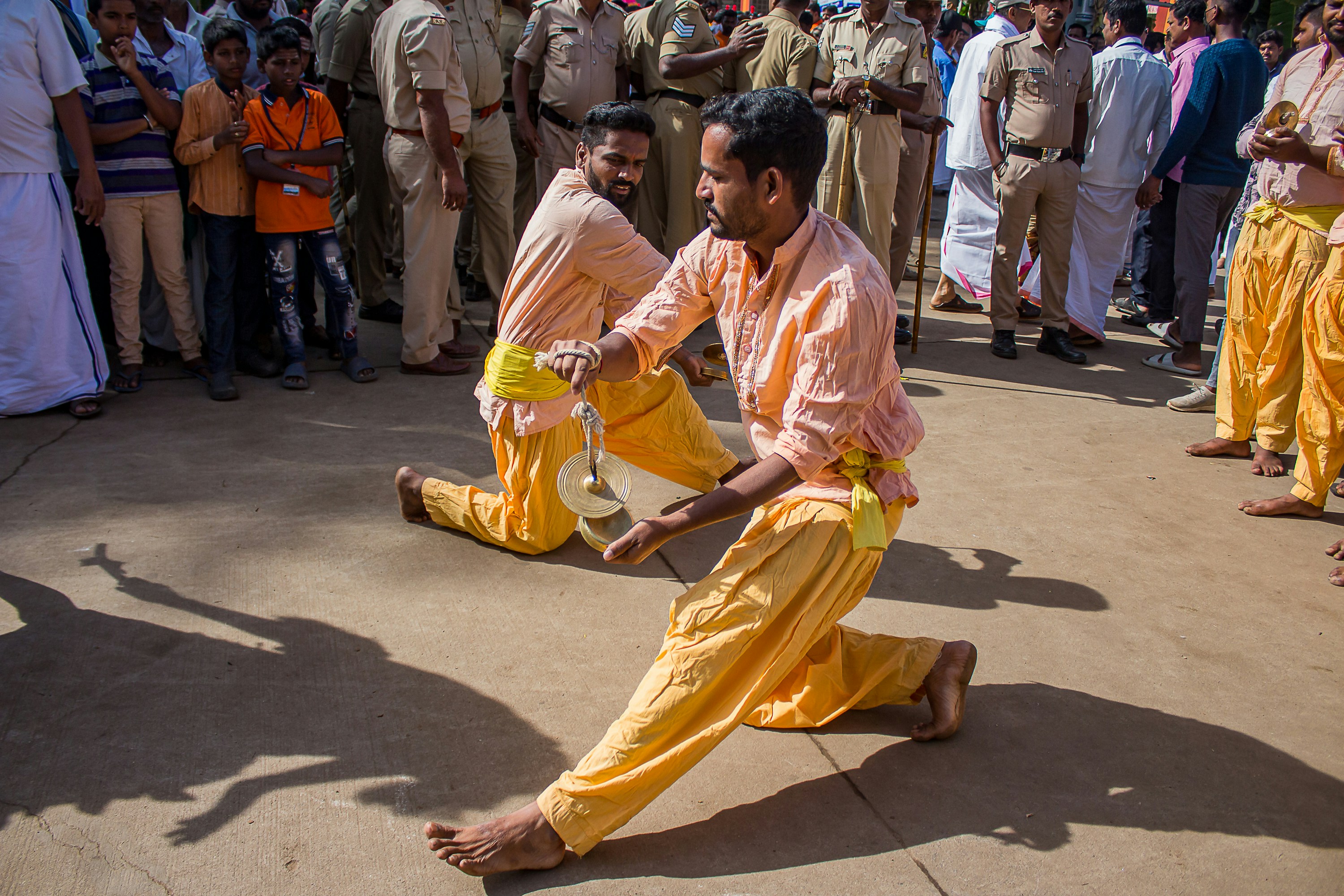 Dramatic Sway: A participant in yellow performs a ceremonial swing amid onlookers