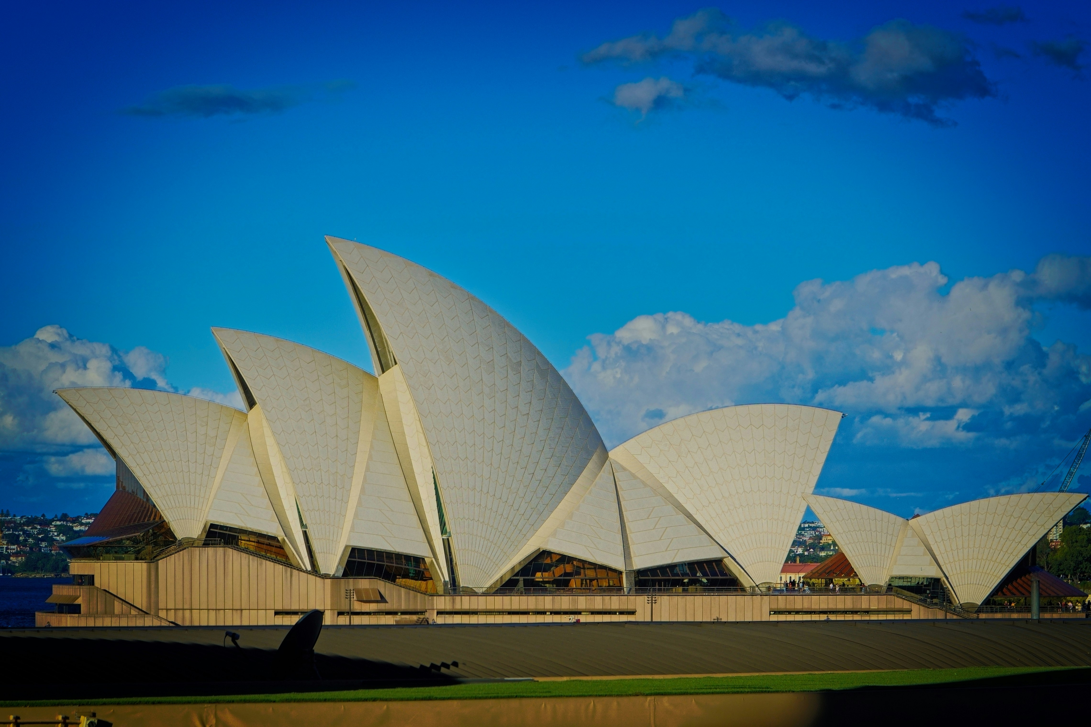 Azure Sky and Sail-Like Silhouettes: The Opera House Beyond the Mound