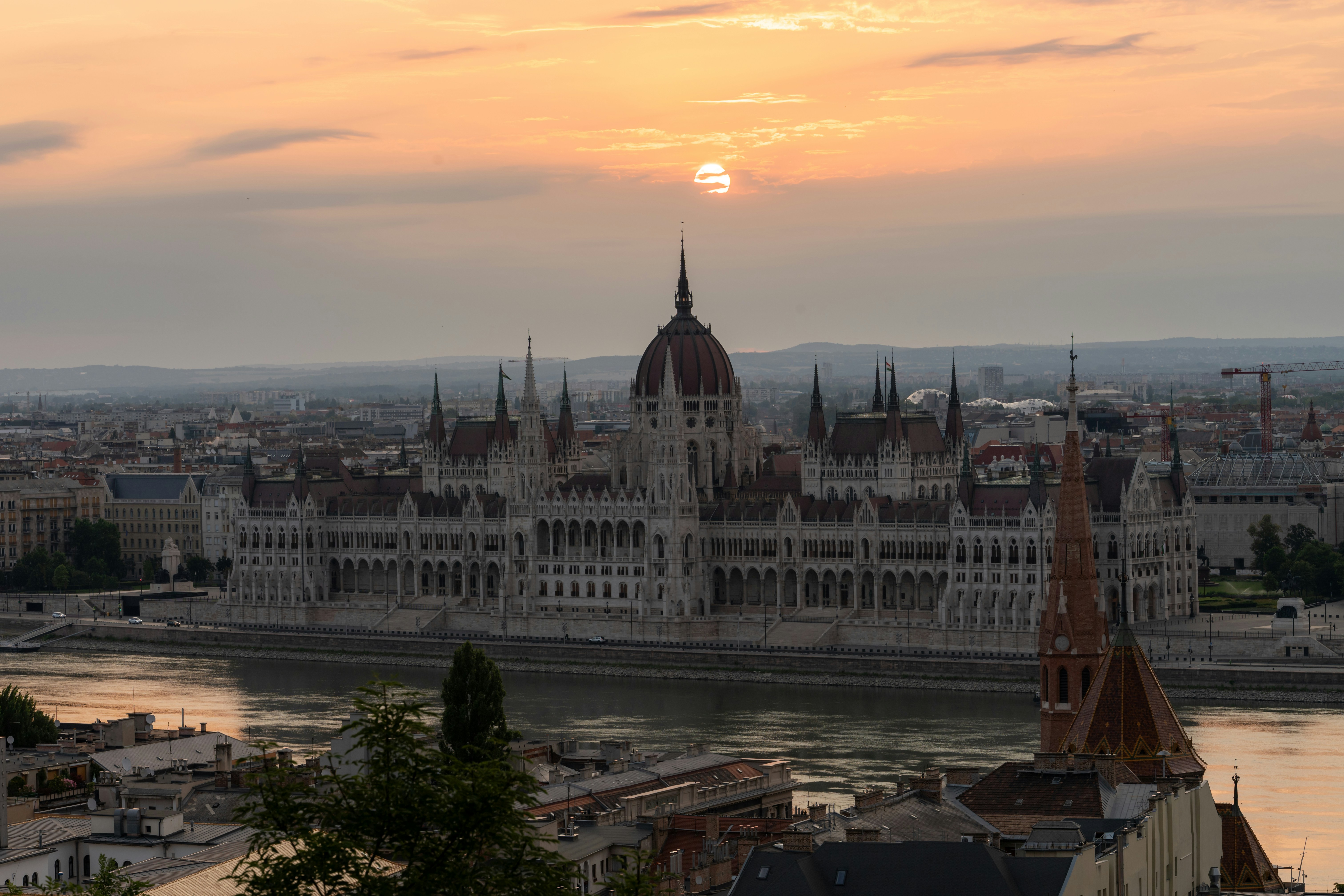Hungarian parliament building at sunset over the danube river