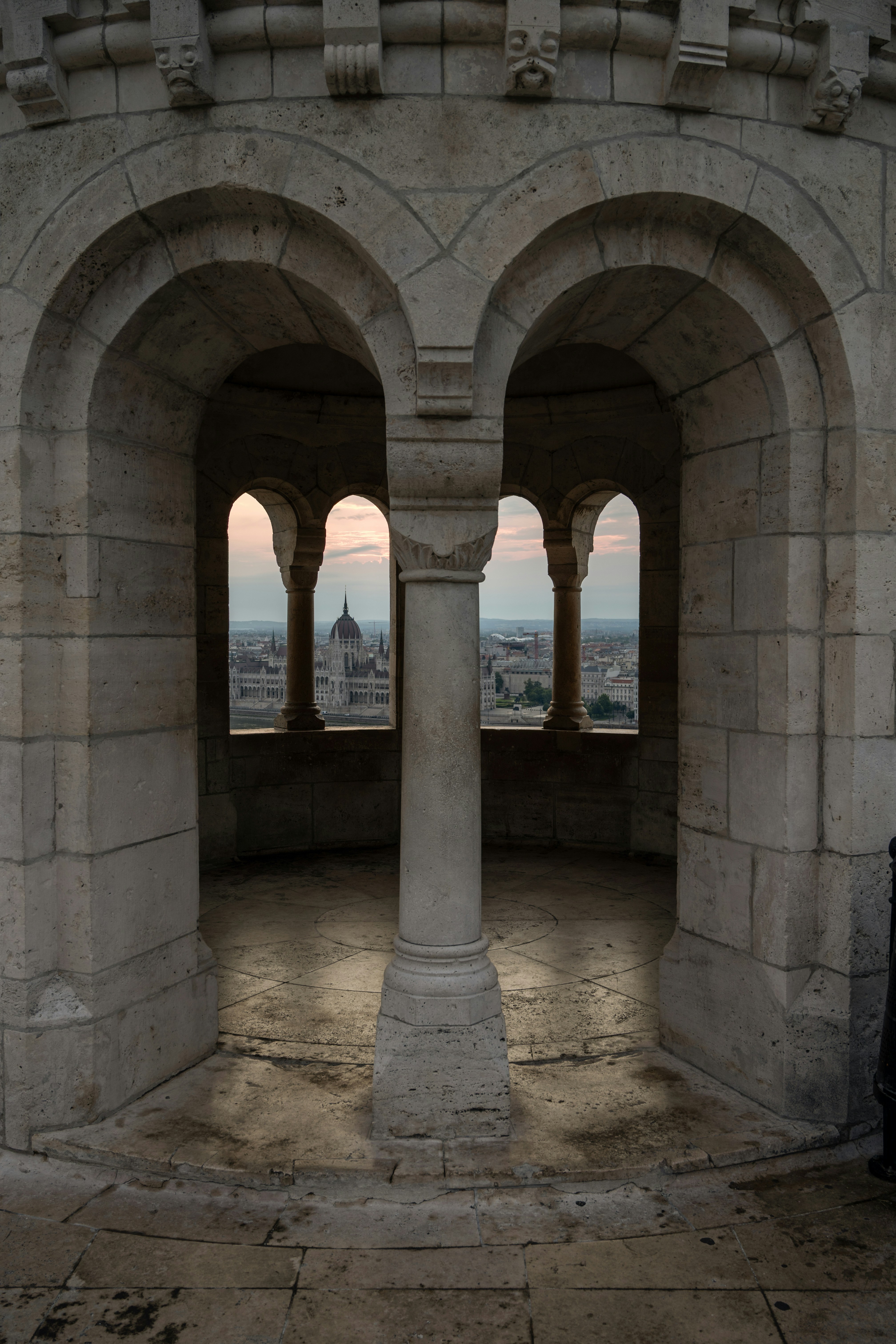 Stone Arcway Framing the Cityscape at Dusk