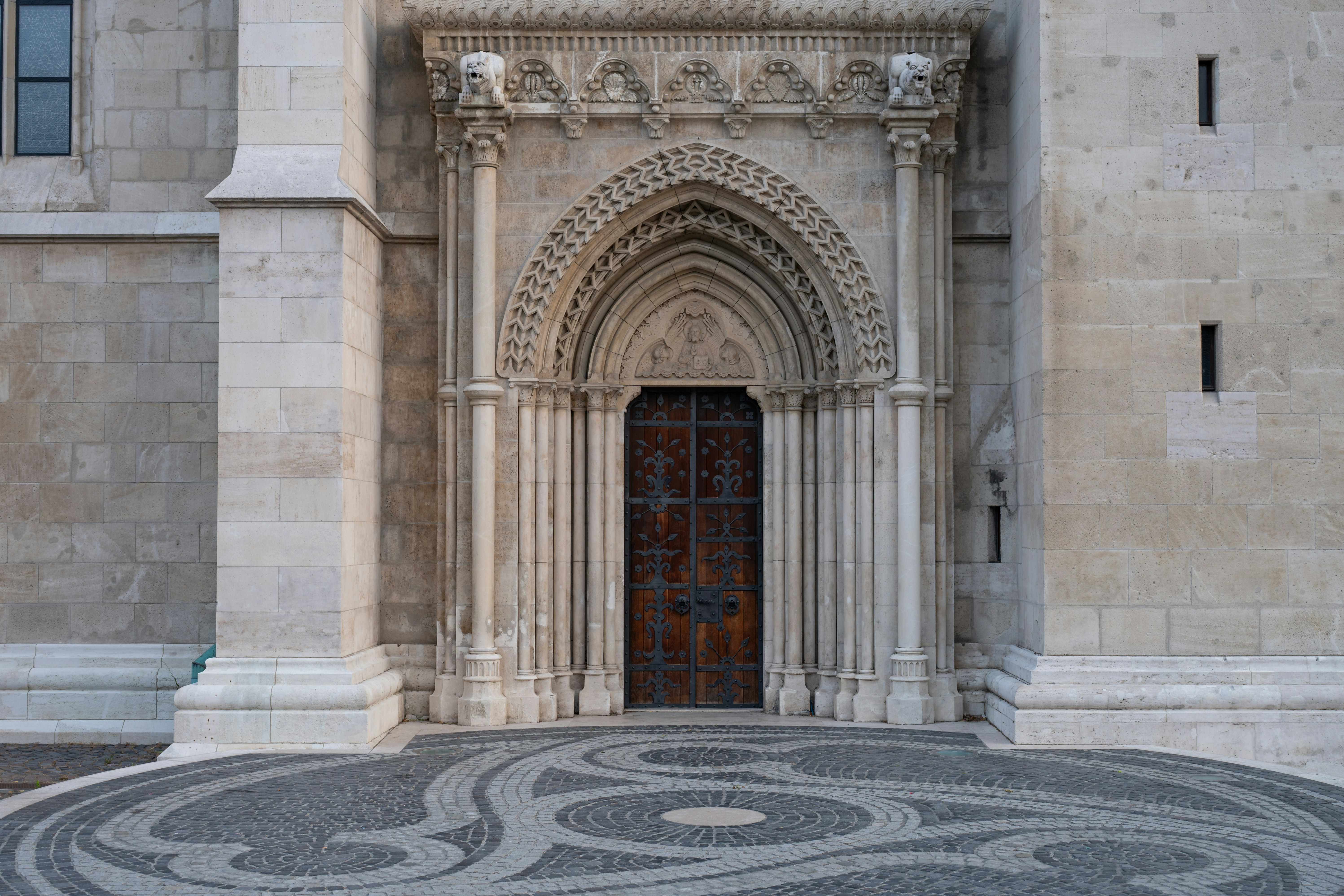 Stone Portal of Repeating Arches: A Doorway Framed by Circular Mosaic Pavement