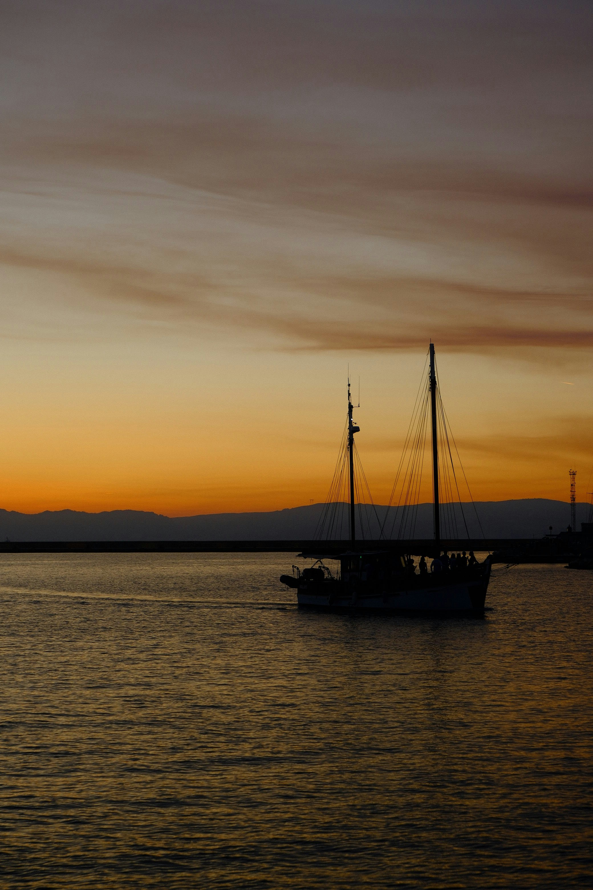 Sunset Harbour: A Sailboat Quietly Drifts at Dusk