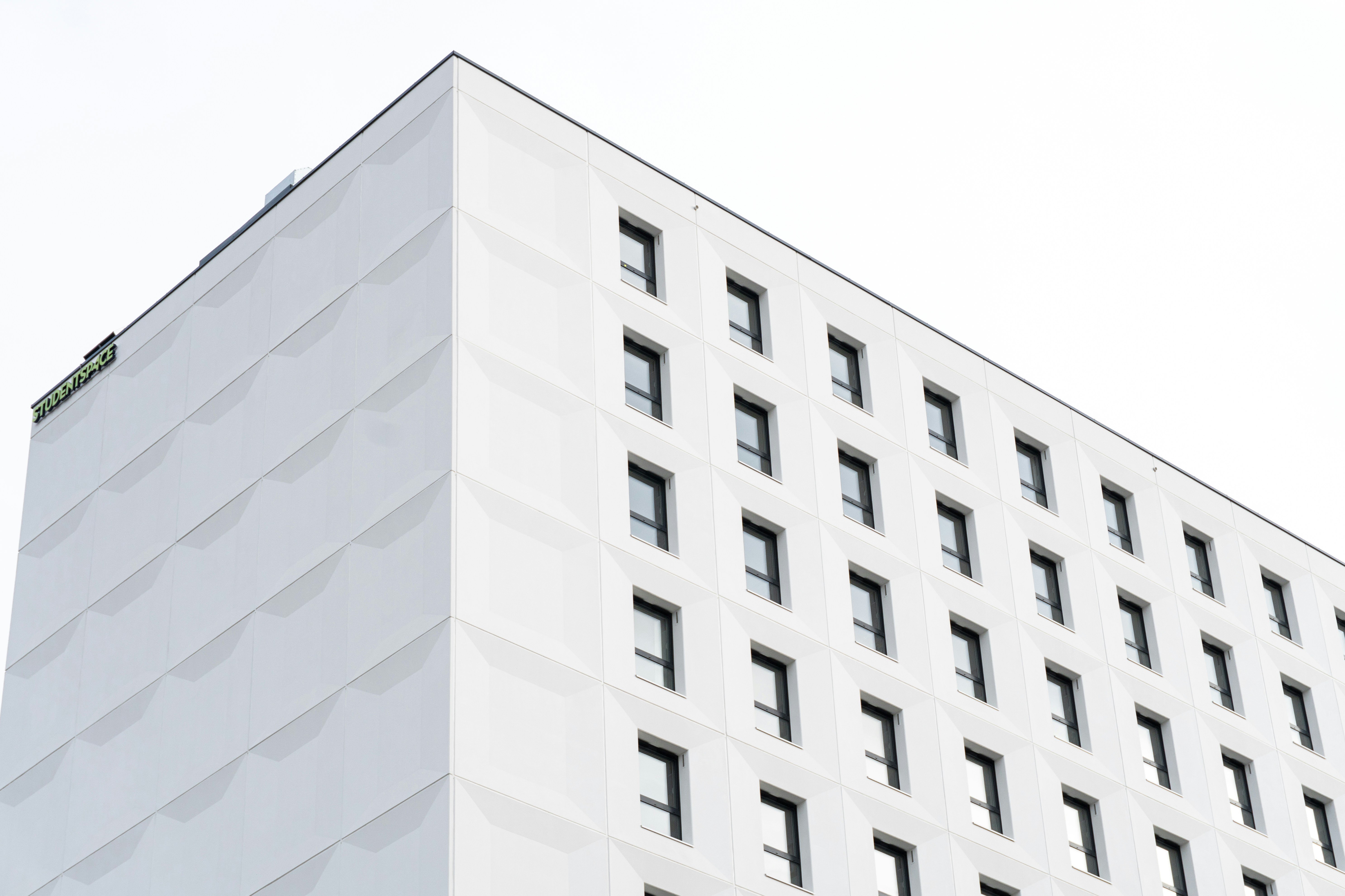 Minimal Prism: A White Facade with Repeating Window Niches