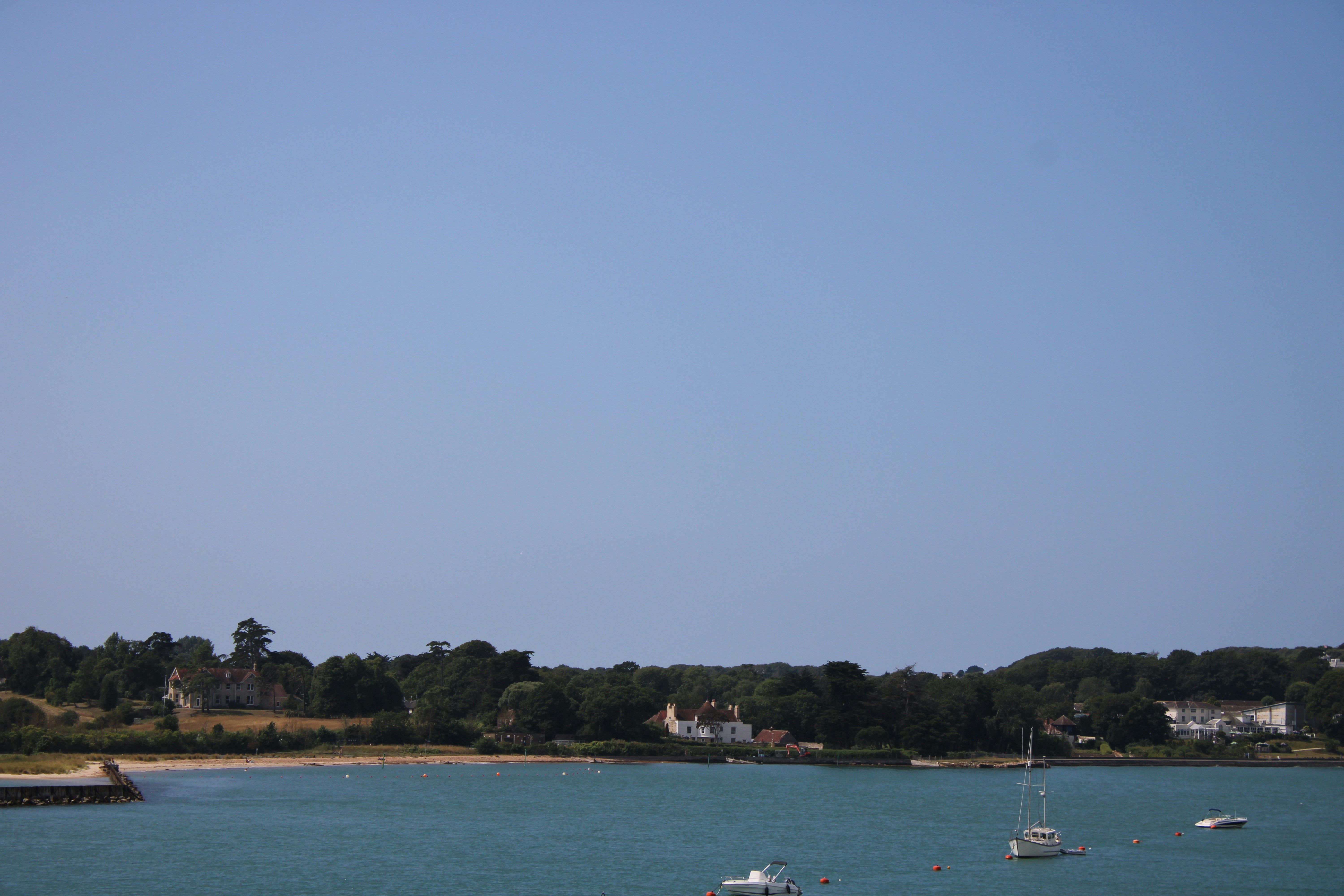Shoreline Vista: Boats at Rest Beneath a Wide Coastal Sky