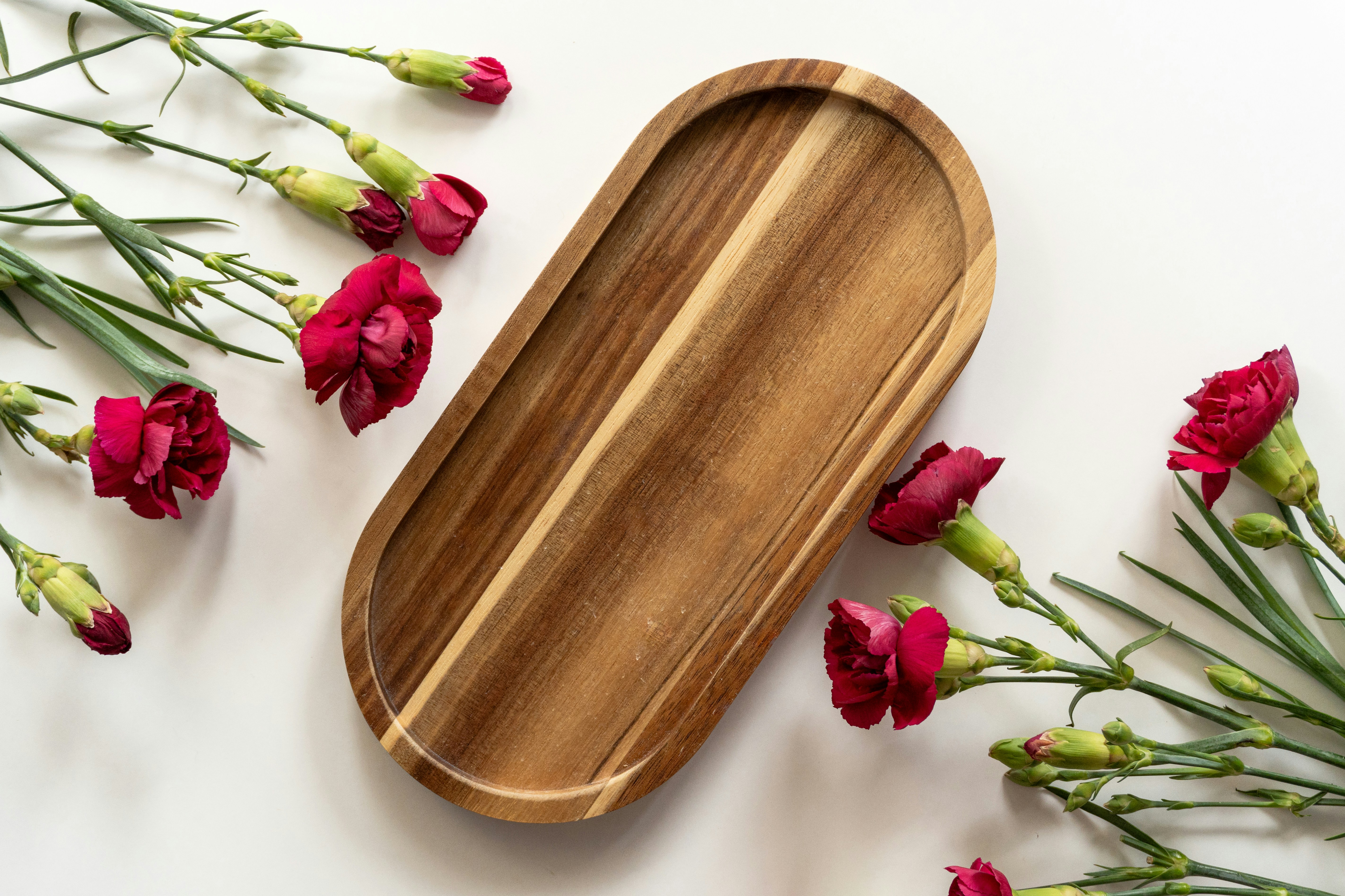 Wooden Tray Centerpiece Framed by Crimson Carnations
