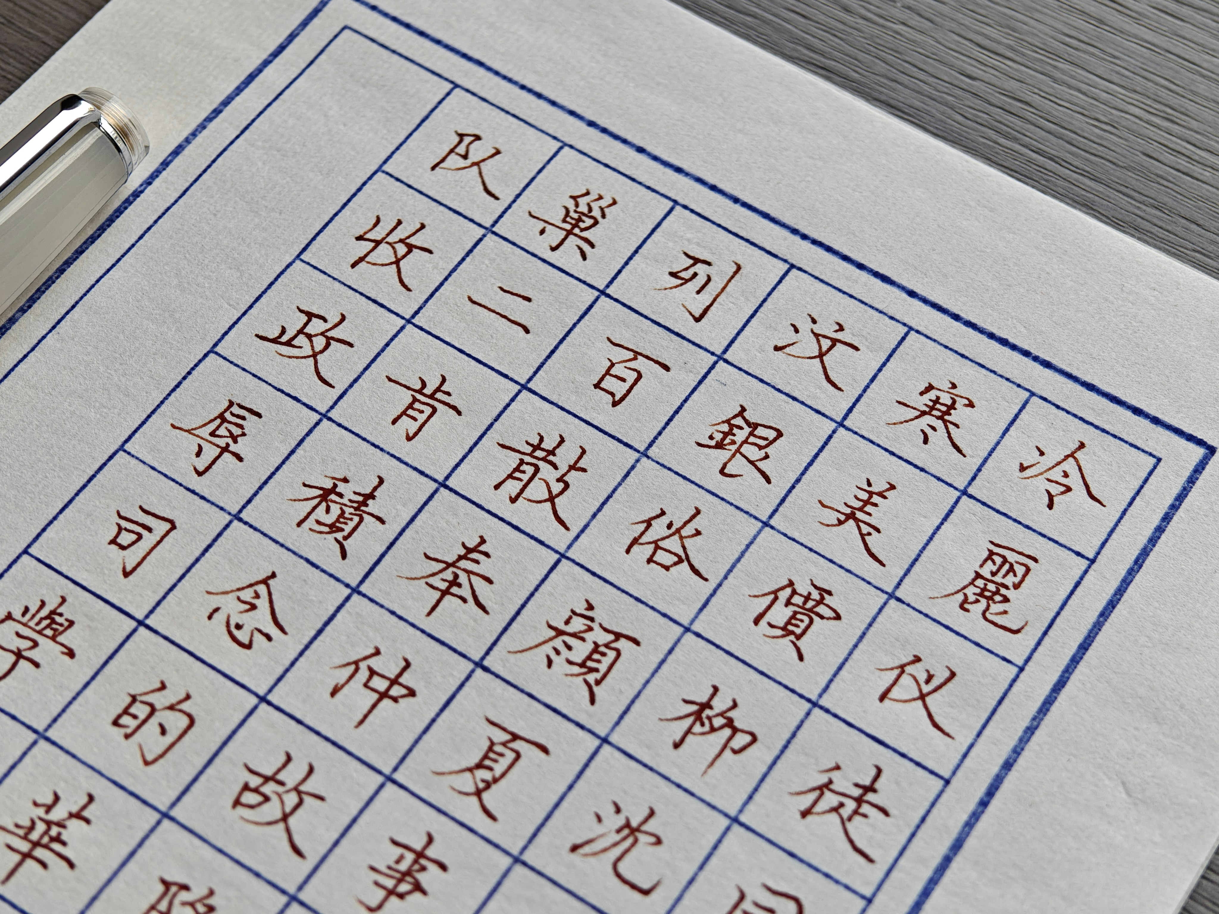 Red Ink Grid: A Close-Up of Calligraphy Tiles in a Notebook