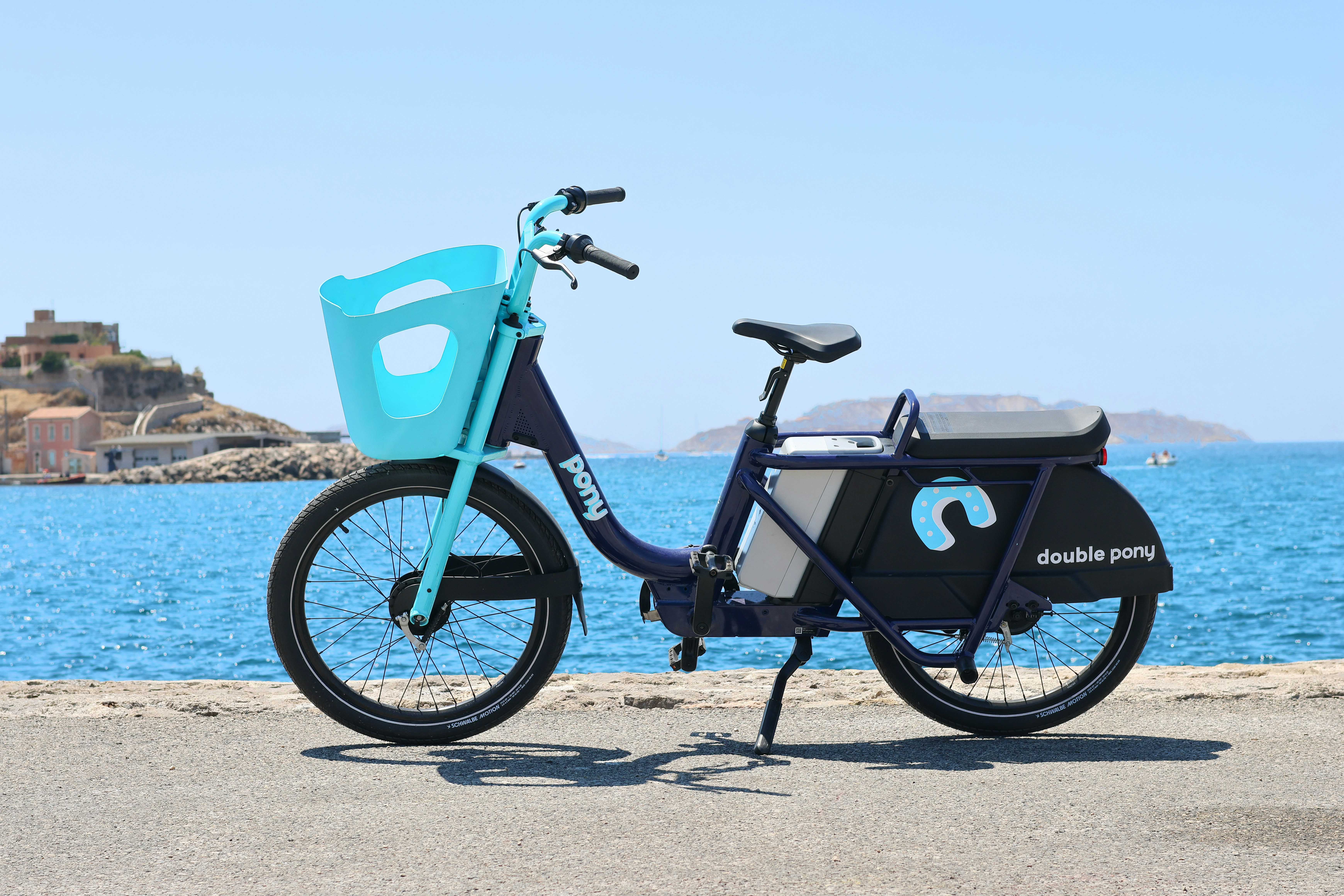 Bright turquoise cargo bike by the sea
