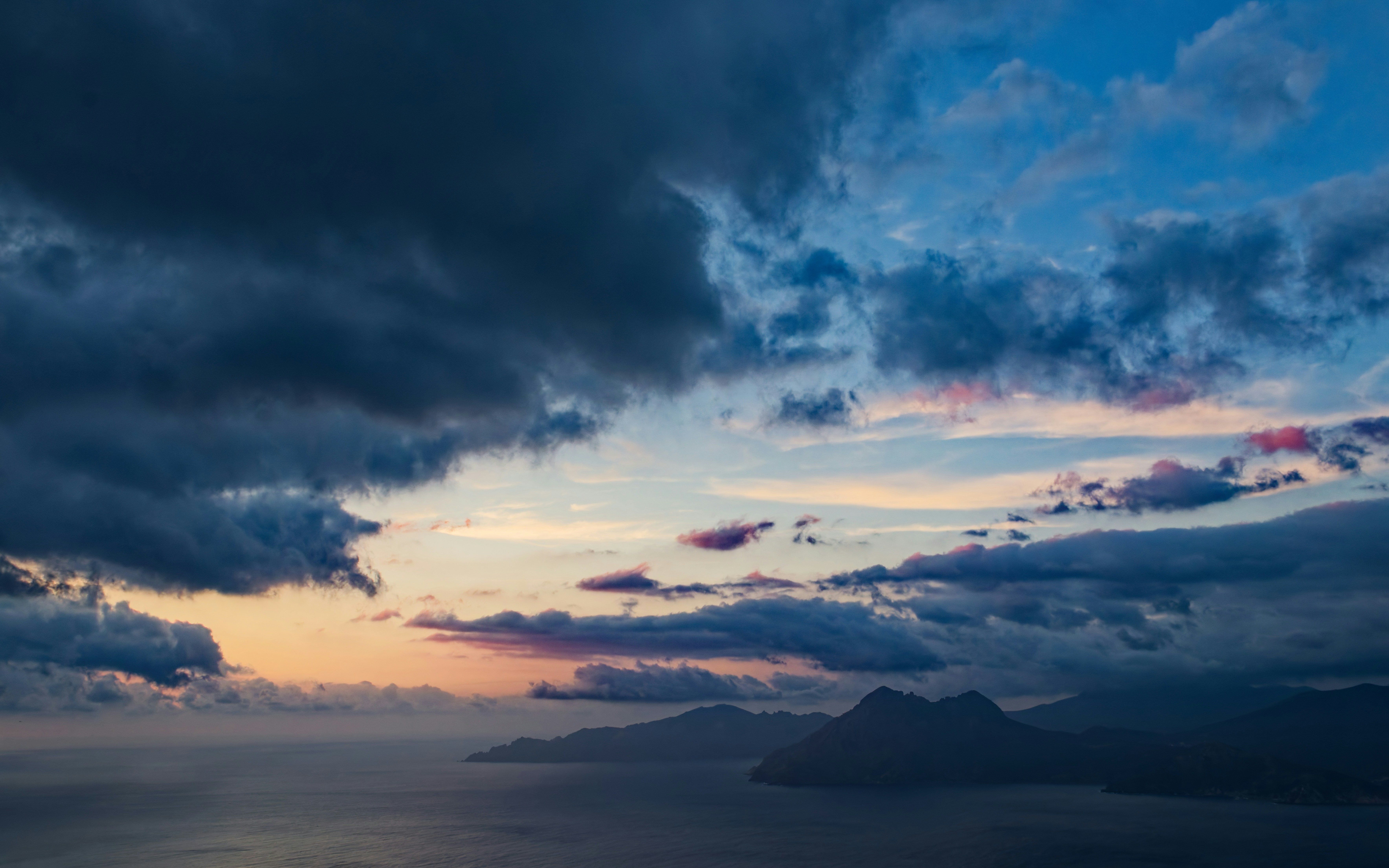 Distant Peaks at Dusk Over a Tranquil Ocean