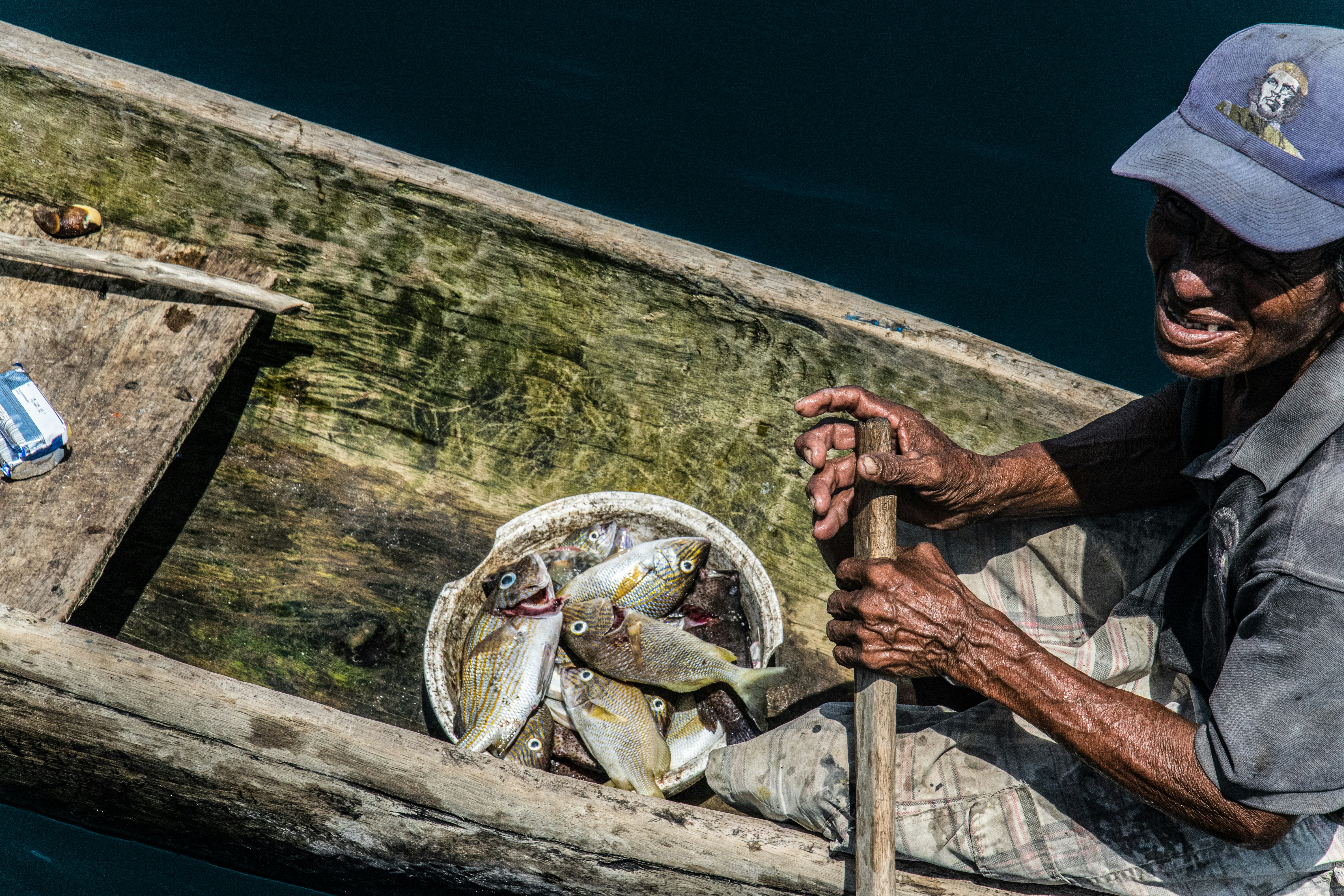 Oars and Catch: A Fisherman’s Bounty in a Weathered Boat