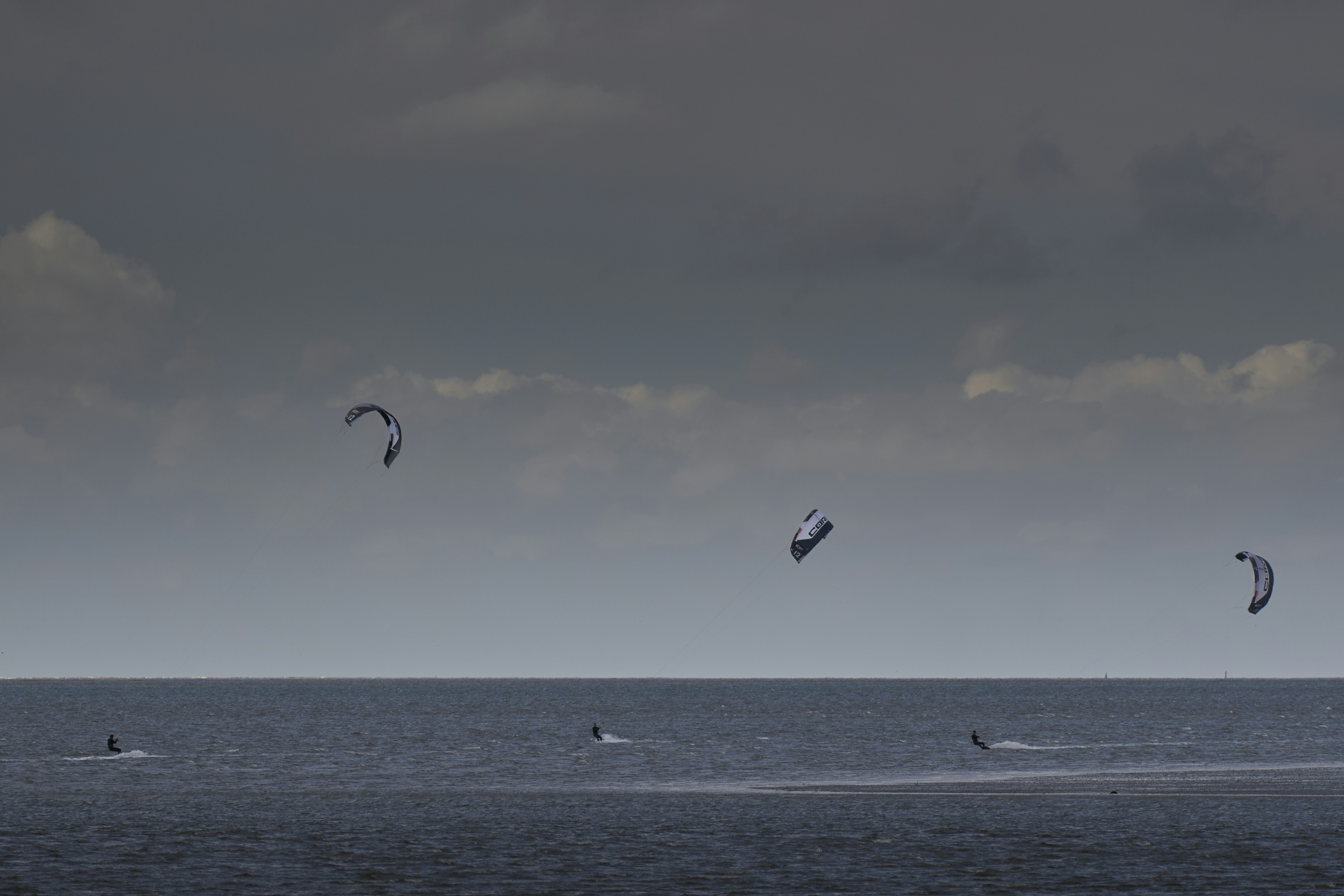Kite Surfers Piercing a Quiet Horizon