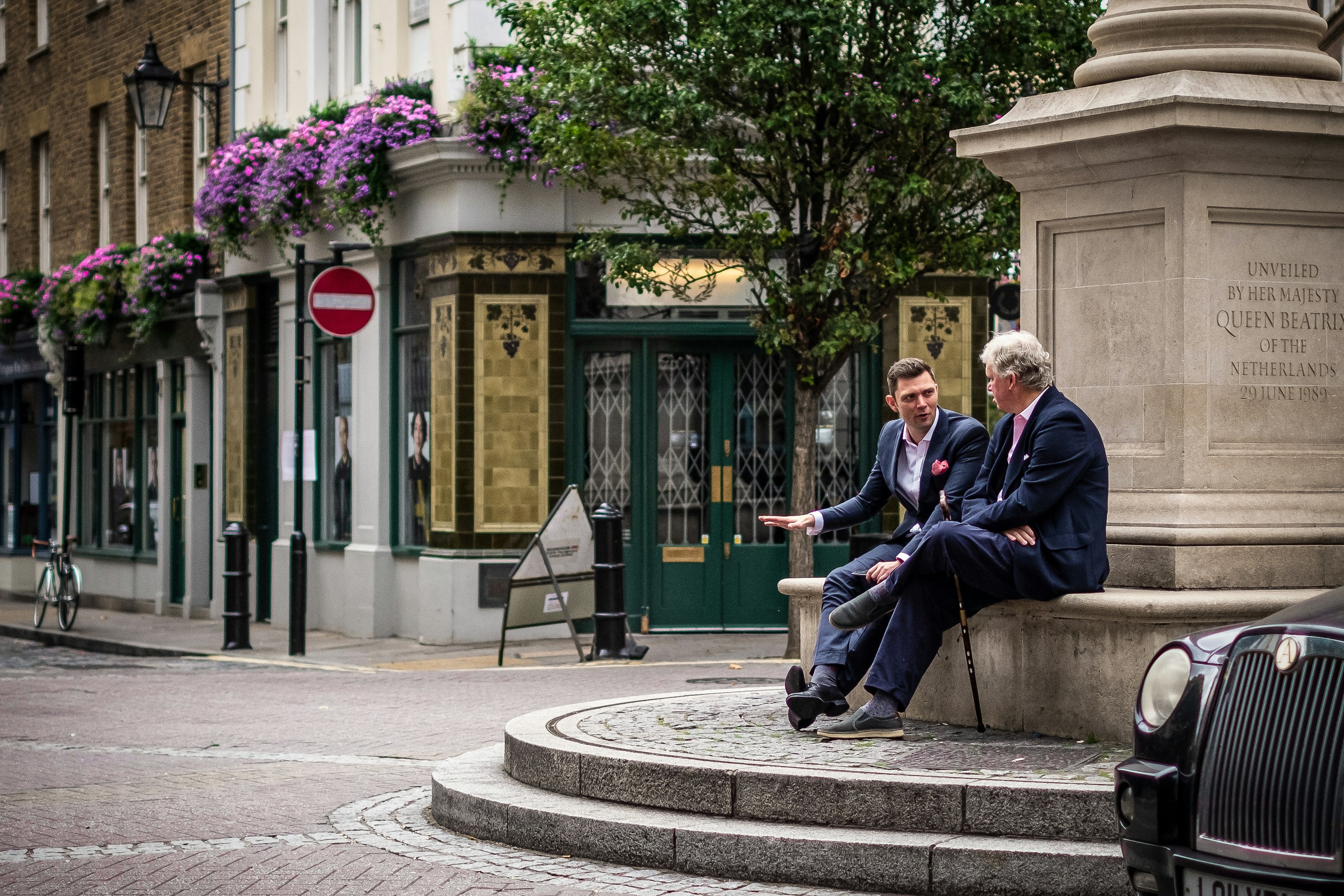 Two Gentlemen on Stone Steps: A Quiet Moment by a London Corner