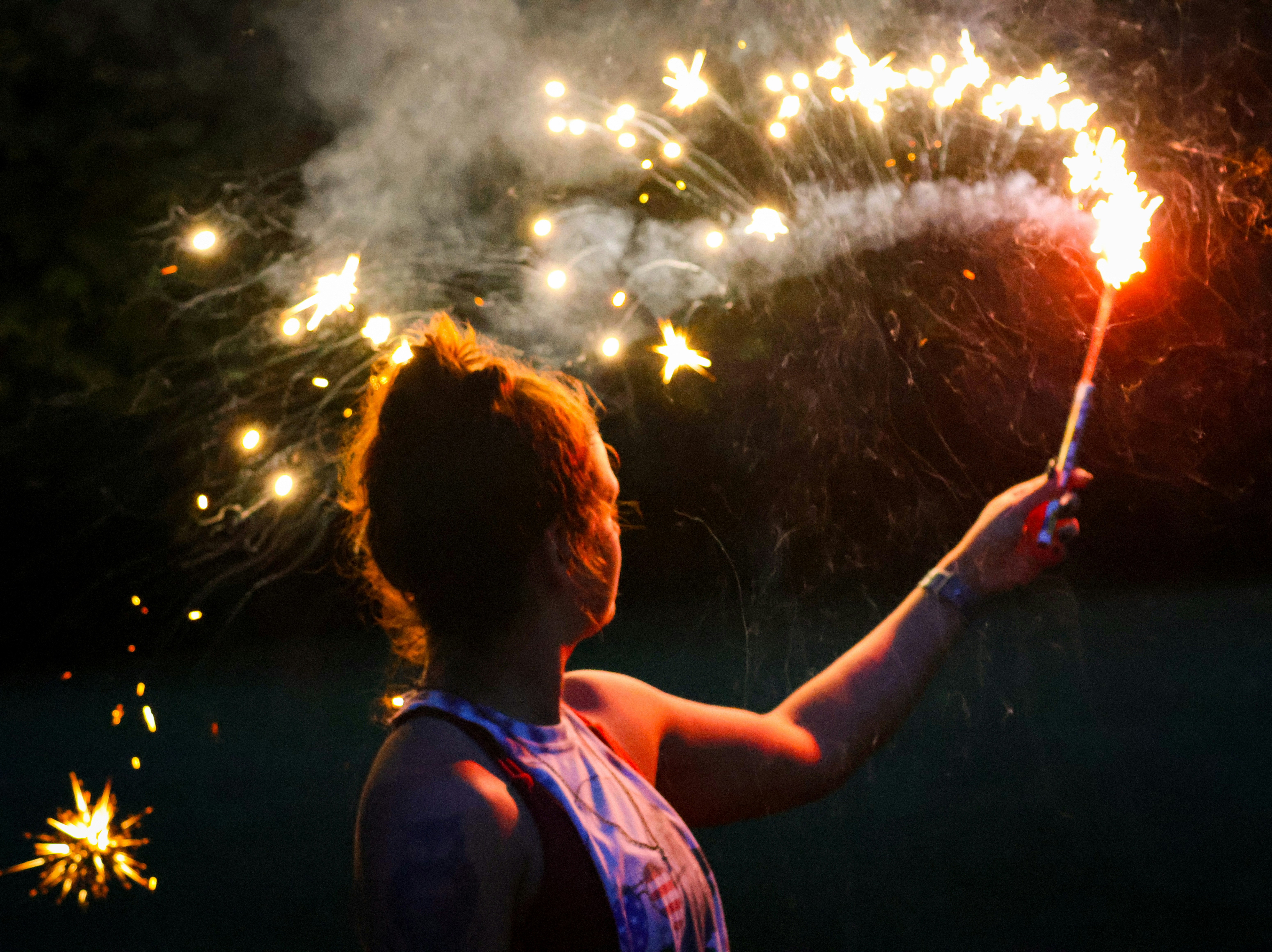 Firework wand: a performer ignites night with spark and silhouette