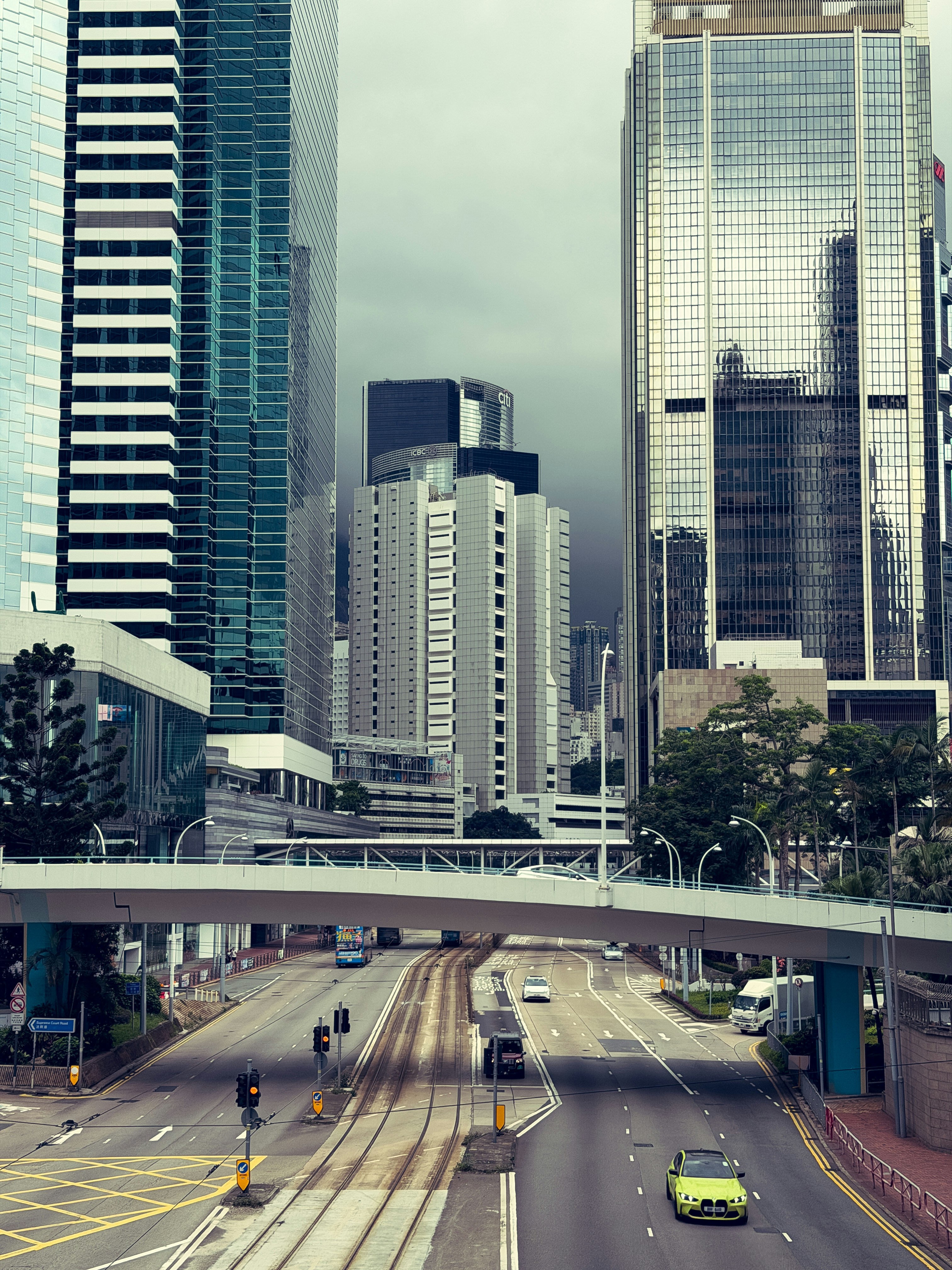 Urban Ribbon: Cars Cleaving a Glass Canyon Beneath a Sky of Towers