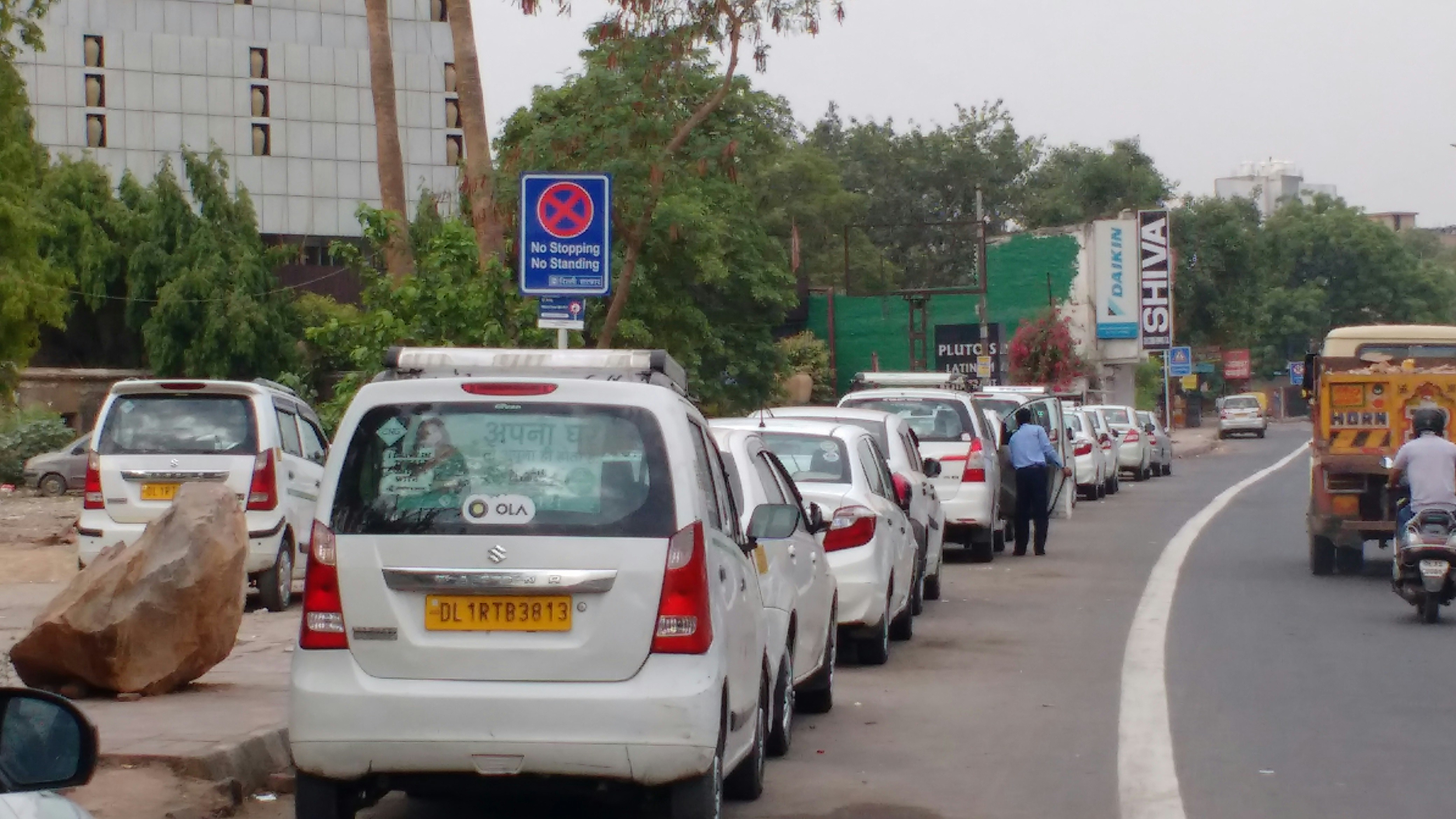 Queue at the City Road cafe: white hatchbacks lined up under a hazy sky