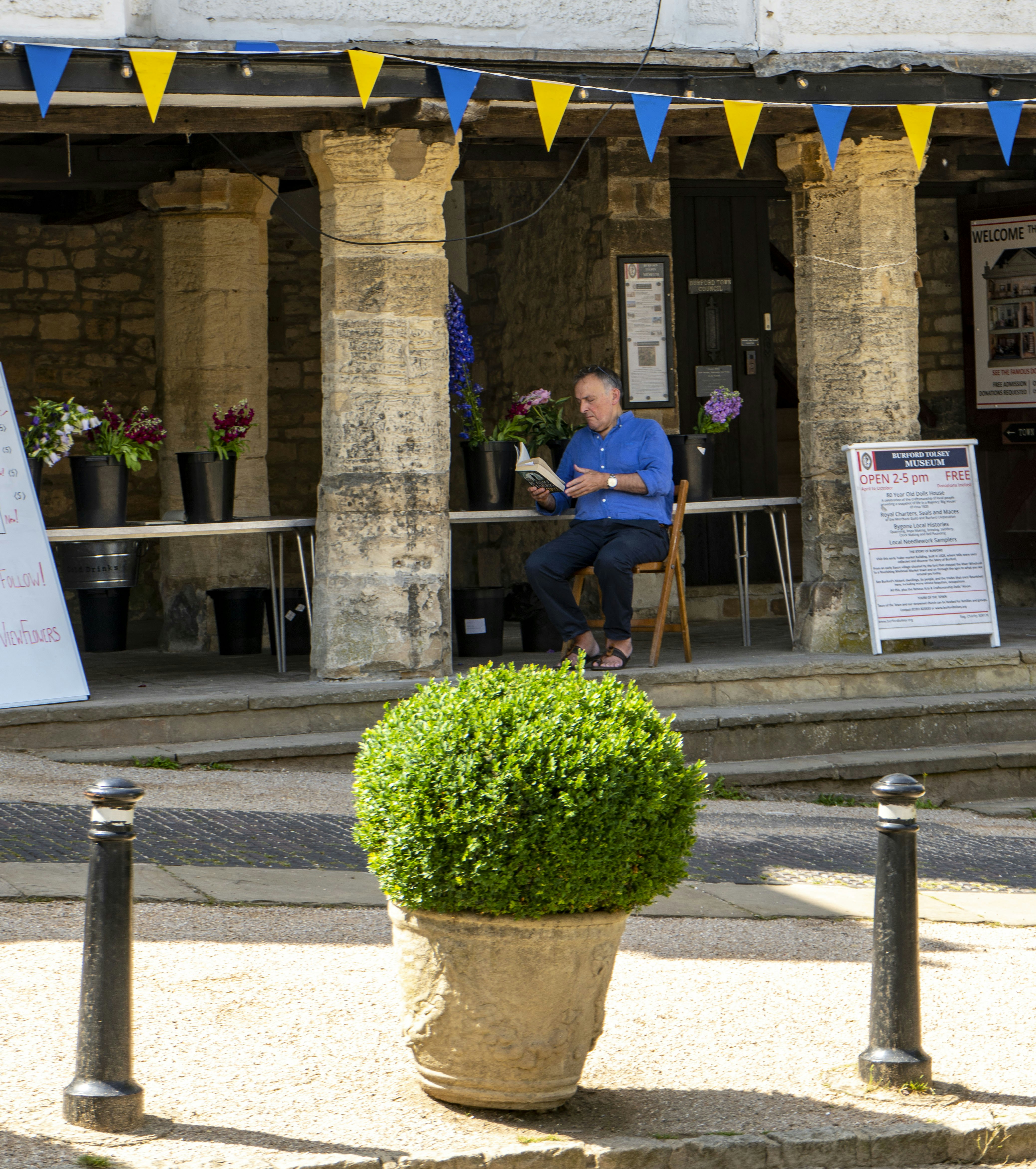 Reader on the Front Porch: A Quiet Moment by the Stone Walkway