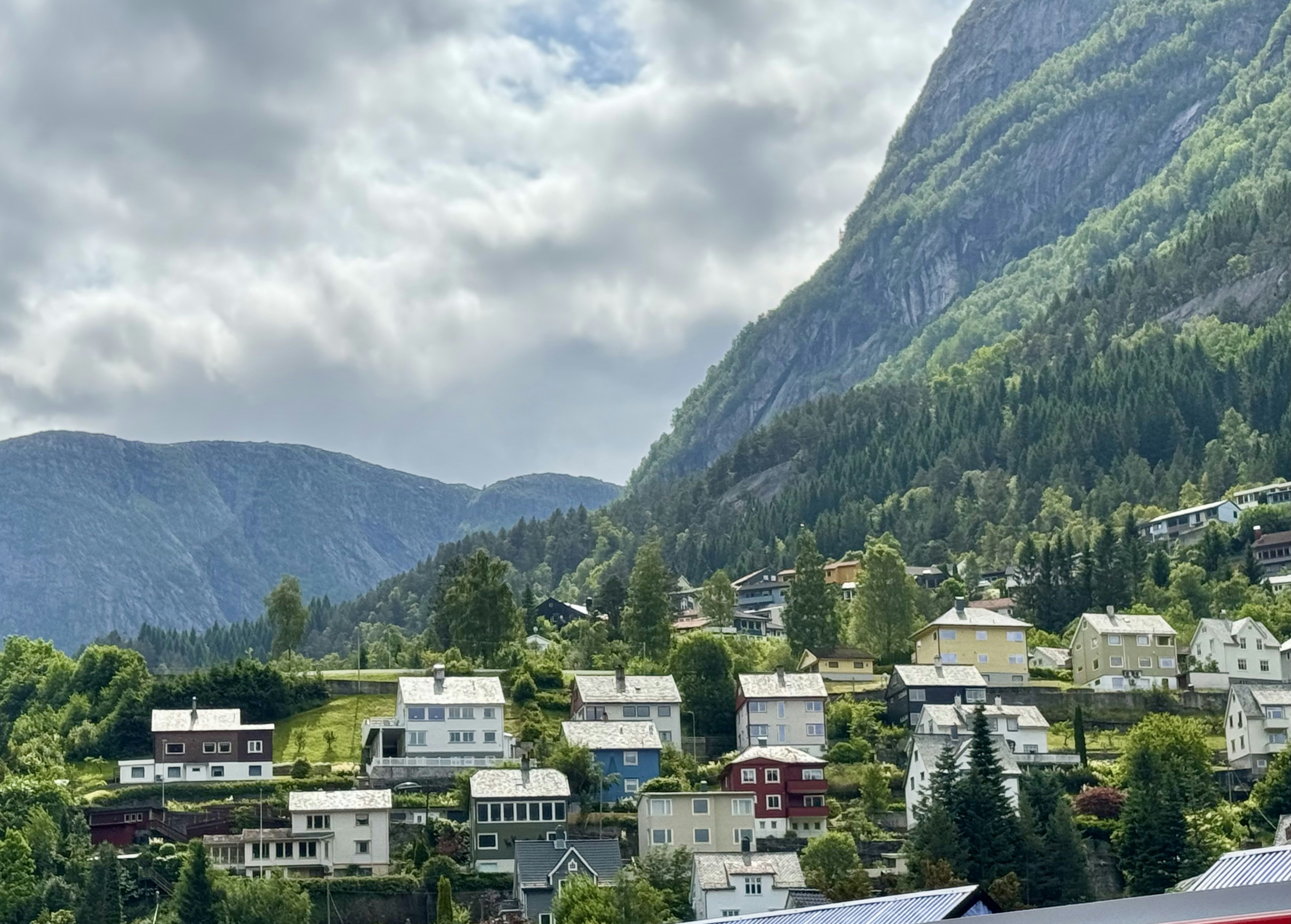 Village in a Green Valley Nestled at the Foot of Towering Peaks