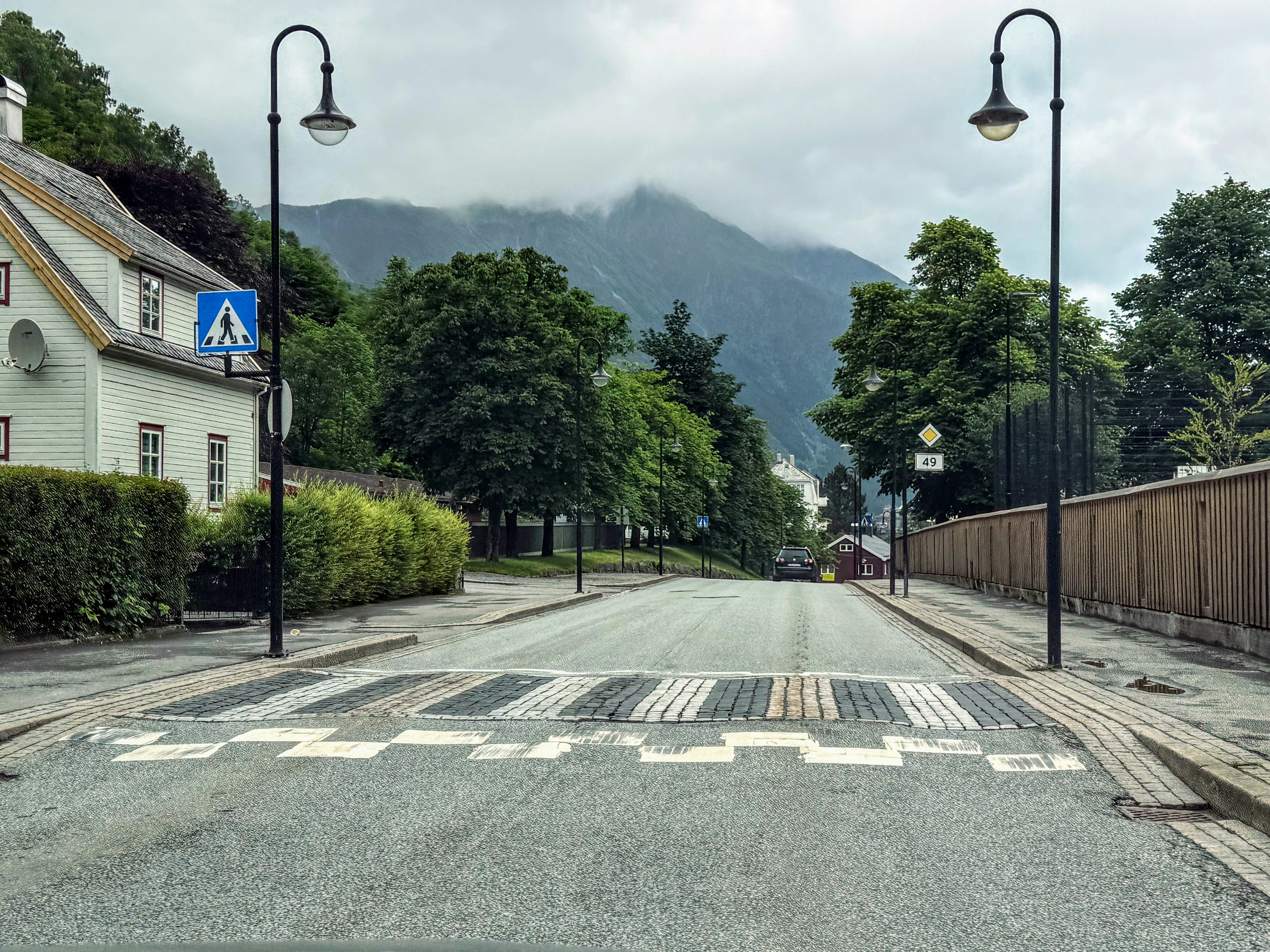 A Quiet Panoramic Street Under Cloudy Peaks